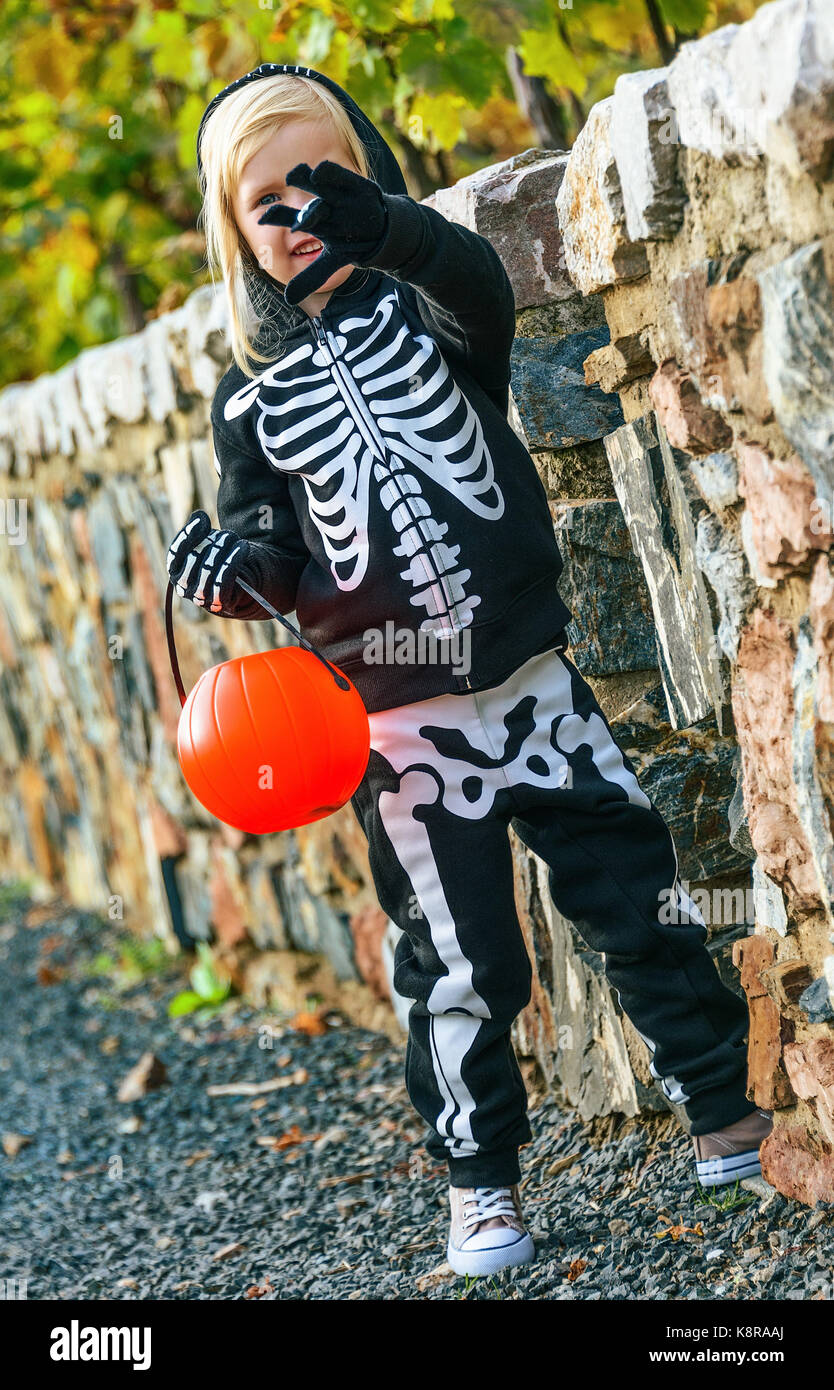Trick or Treat. child wearing skeleton costume on Halloween outdoors ...