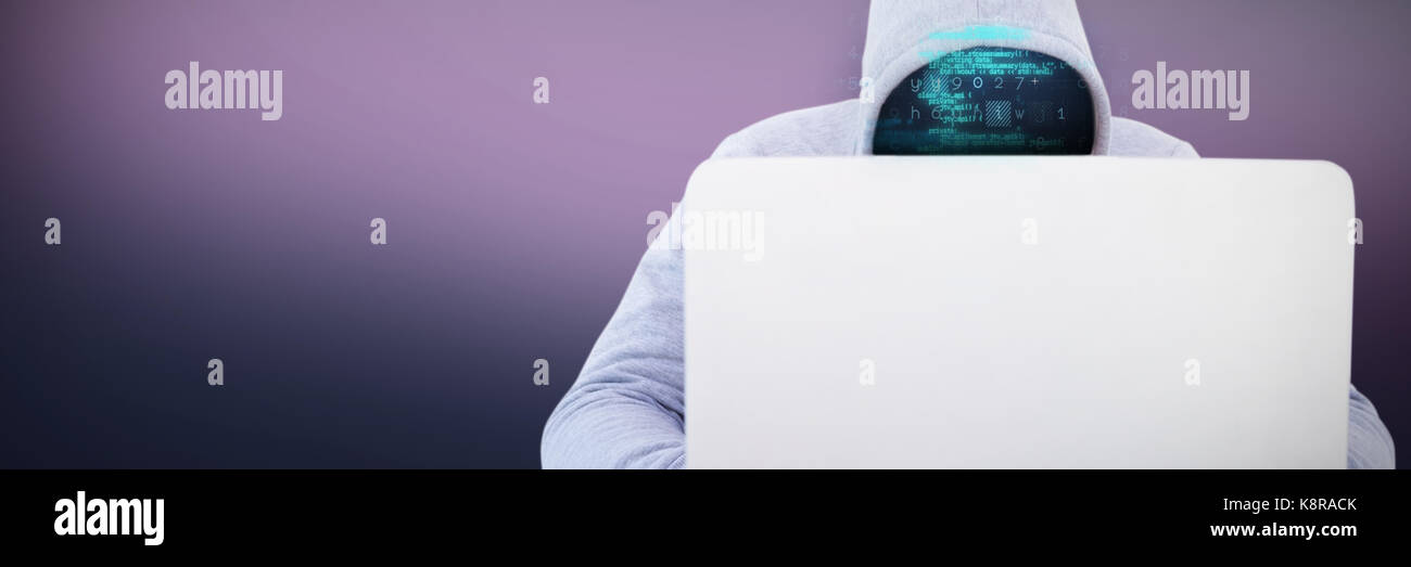 Hacker using white laptop at table against purple and pink background ...