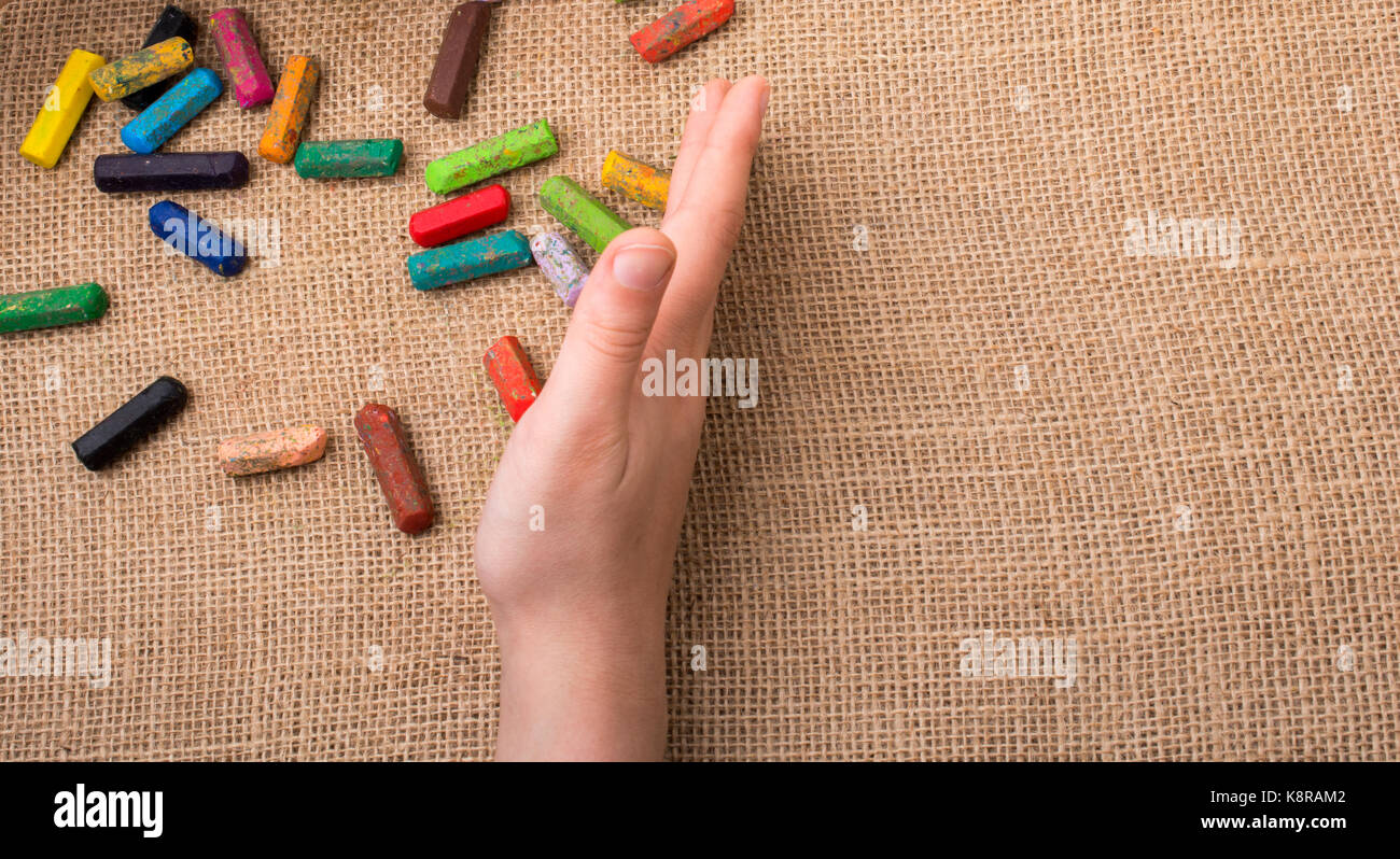 Used color crayons and a hand holding some Stock Photo - Alamy