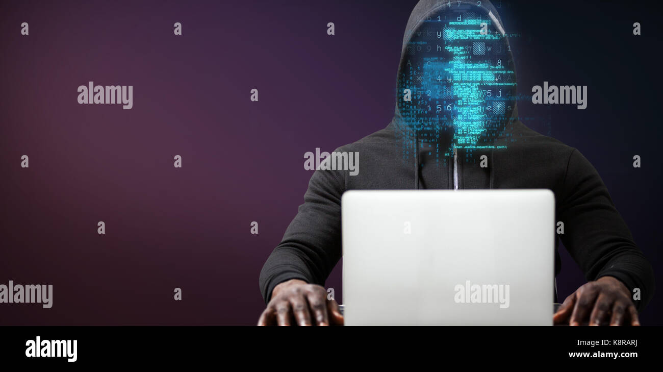 Male hacker with laptop on table against pink and purple colors ...