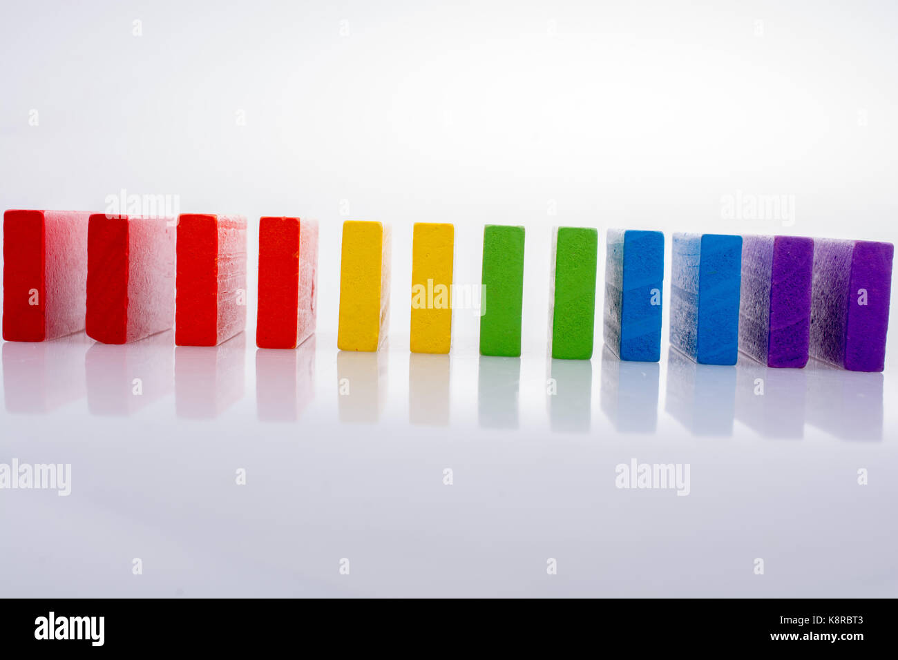 Colorful Domino Blocks in a line on a white background Stock Photo - Alamy