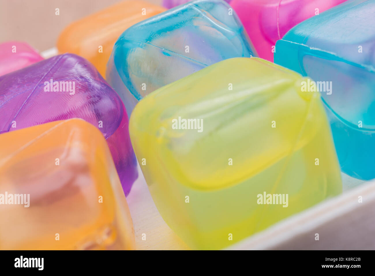 Fake colorful ice cubes on a brown background Stock Photo - Alamy
