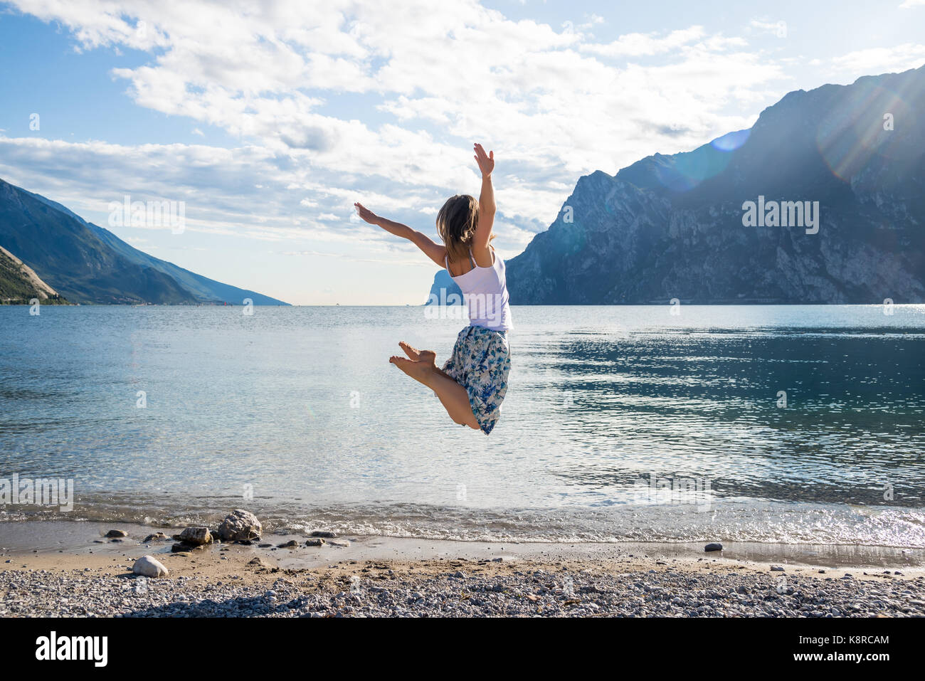Woman jumping at the lake Stock Photo - Alamy