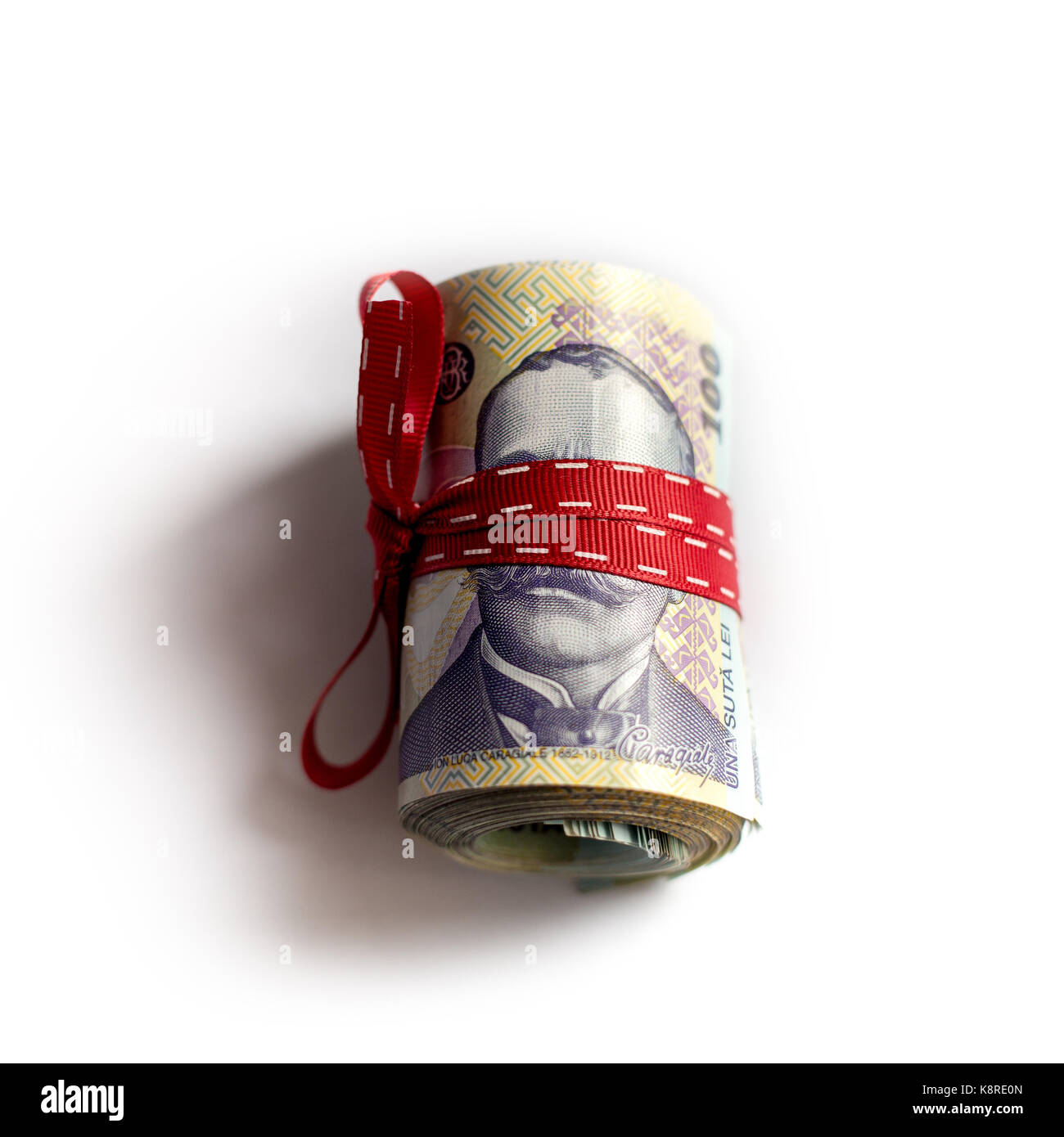 Roll of money isolated on white background with red ribbon, Romanian ...
