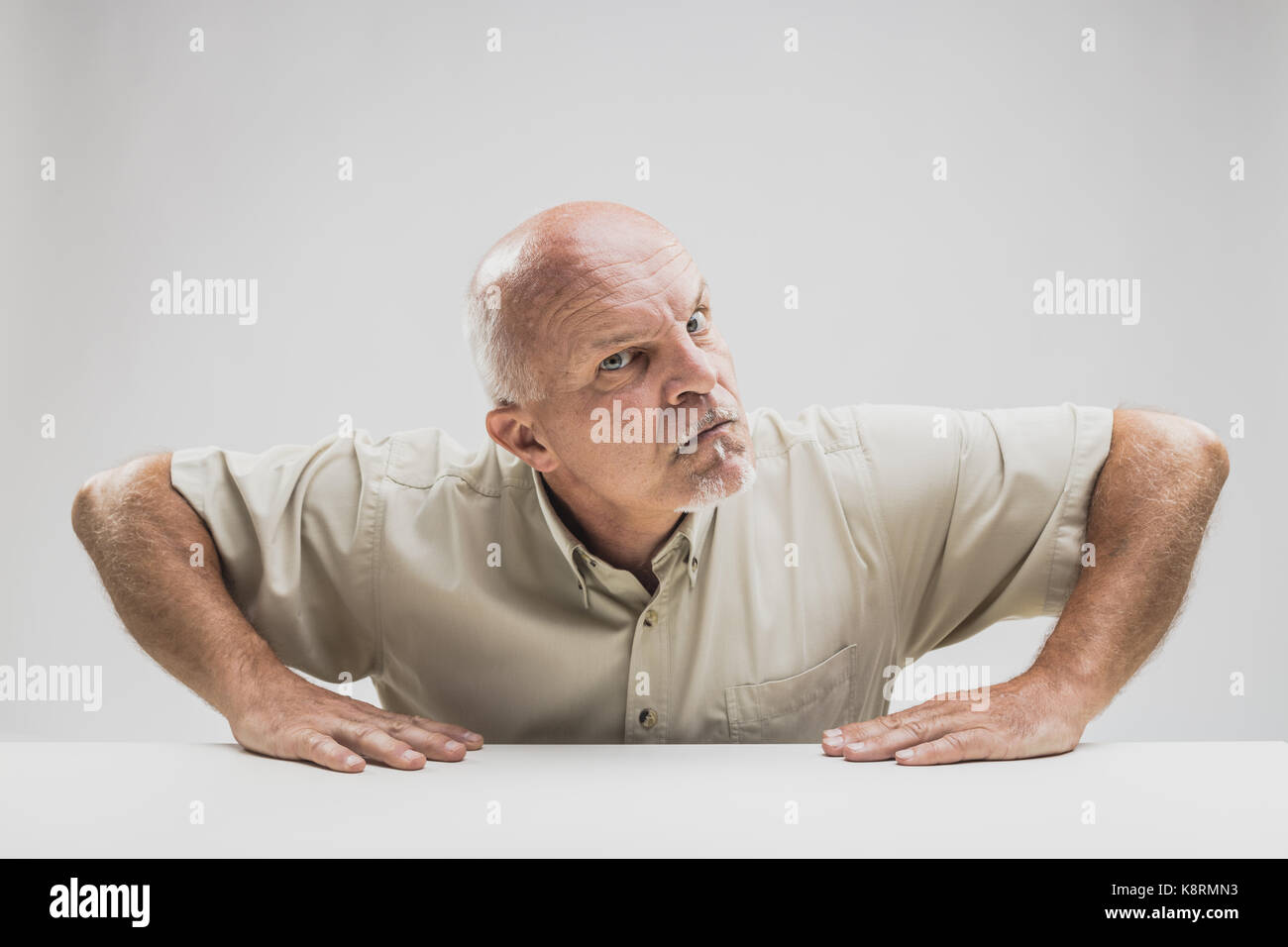 Skeptical disbelieving senior man glaring at the camera with an intense ...