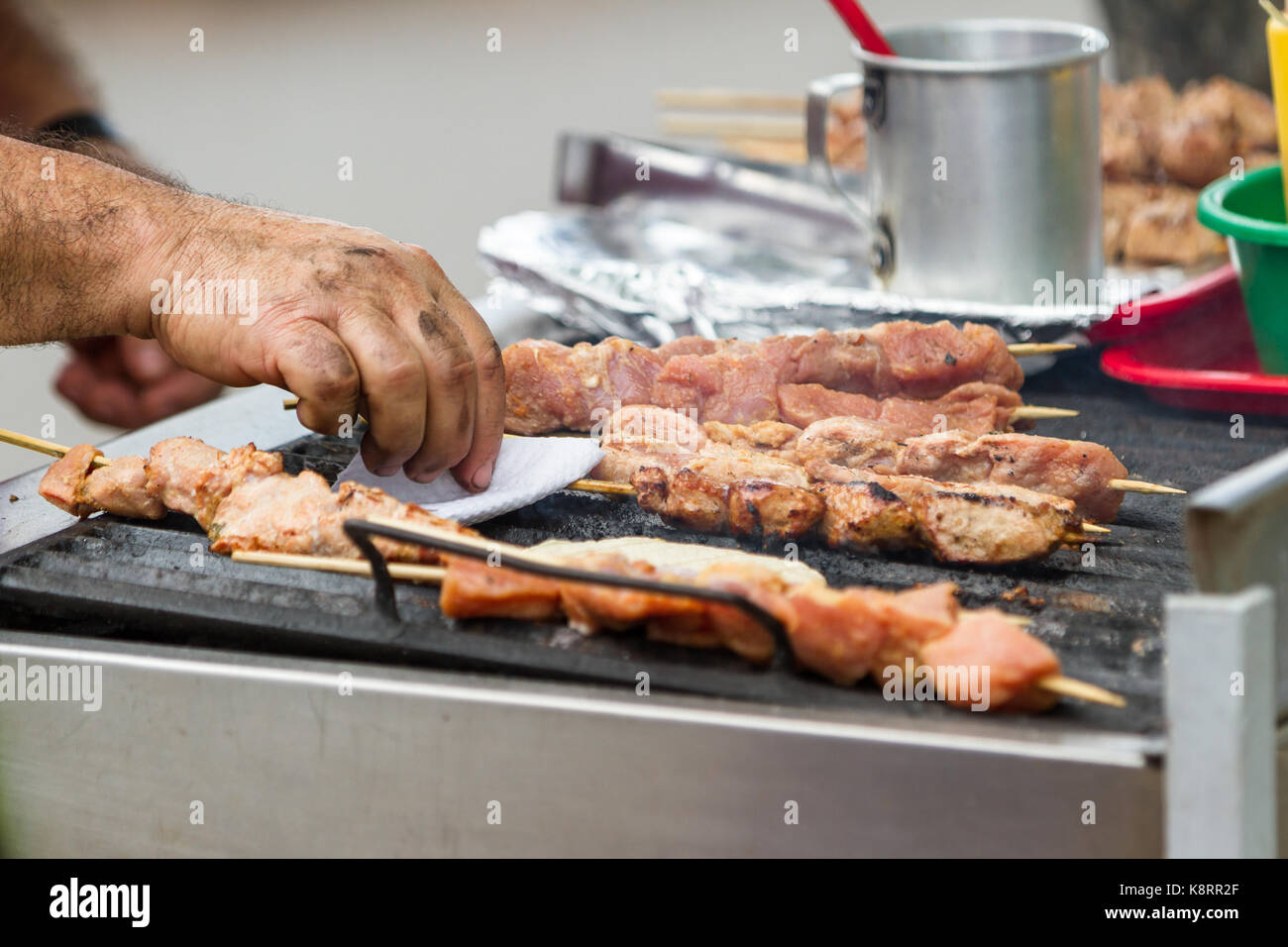 close up of a local mans hands grilling meat outdoors Stock Photo - Alamy