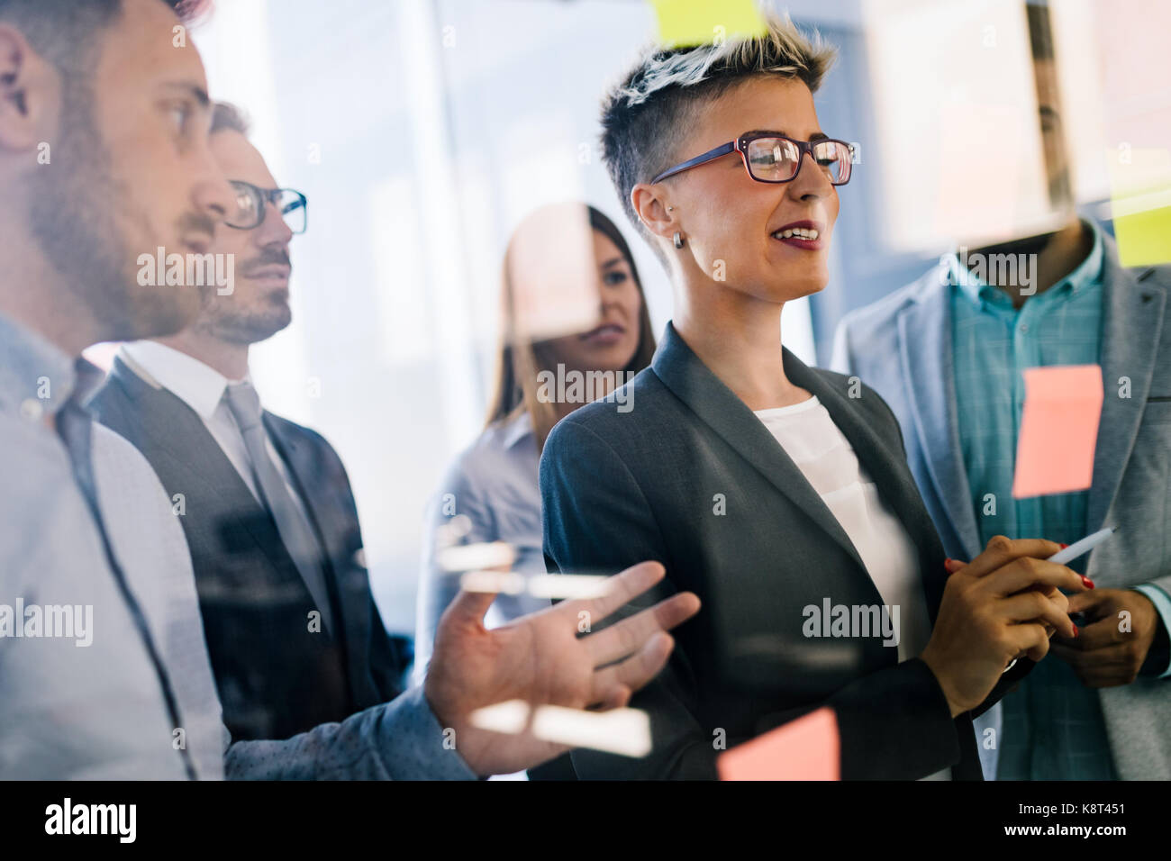 Picture of designers sticking notes in office Stock Photo - Alamy