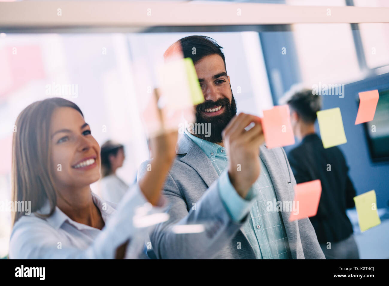 Picture of designers sticking notes in office Stock Photo - Alamy