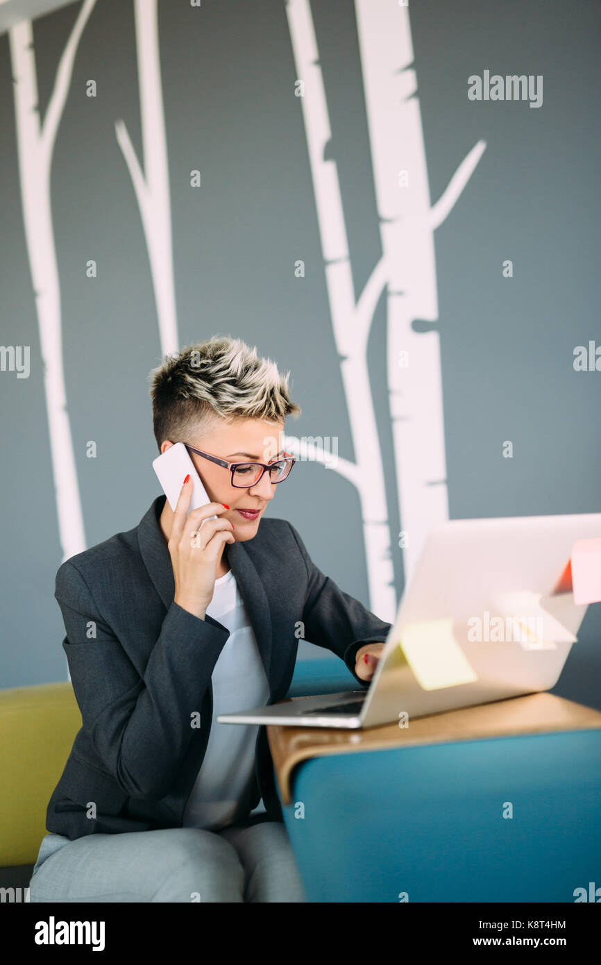 Attractive young female architect working on laptop Stock Photo - Alamy