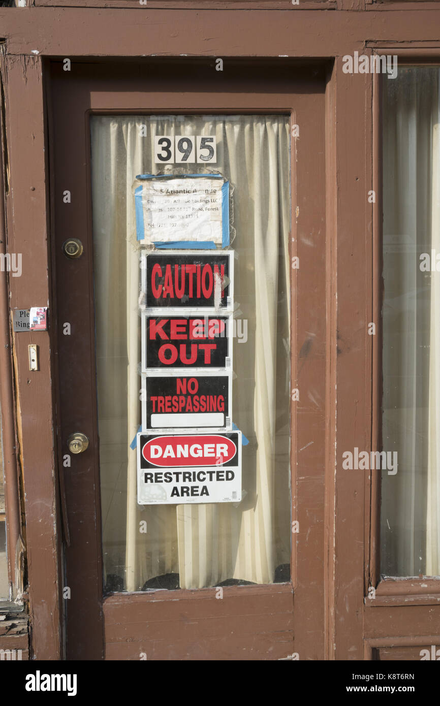 Warning signs on a storefront building in Brooklyn, NY Stock Photo - Alamy