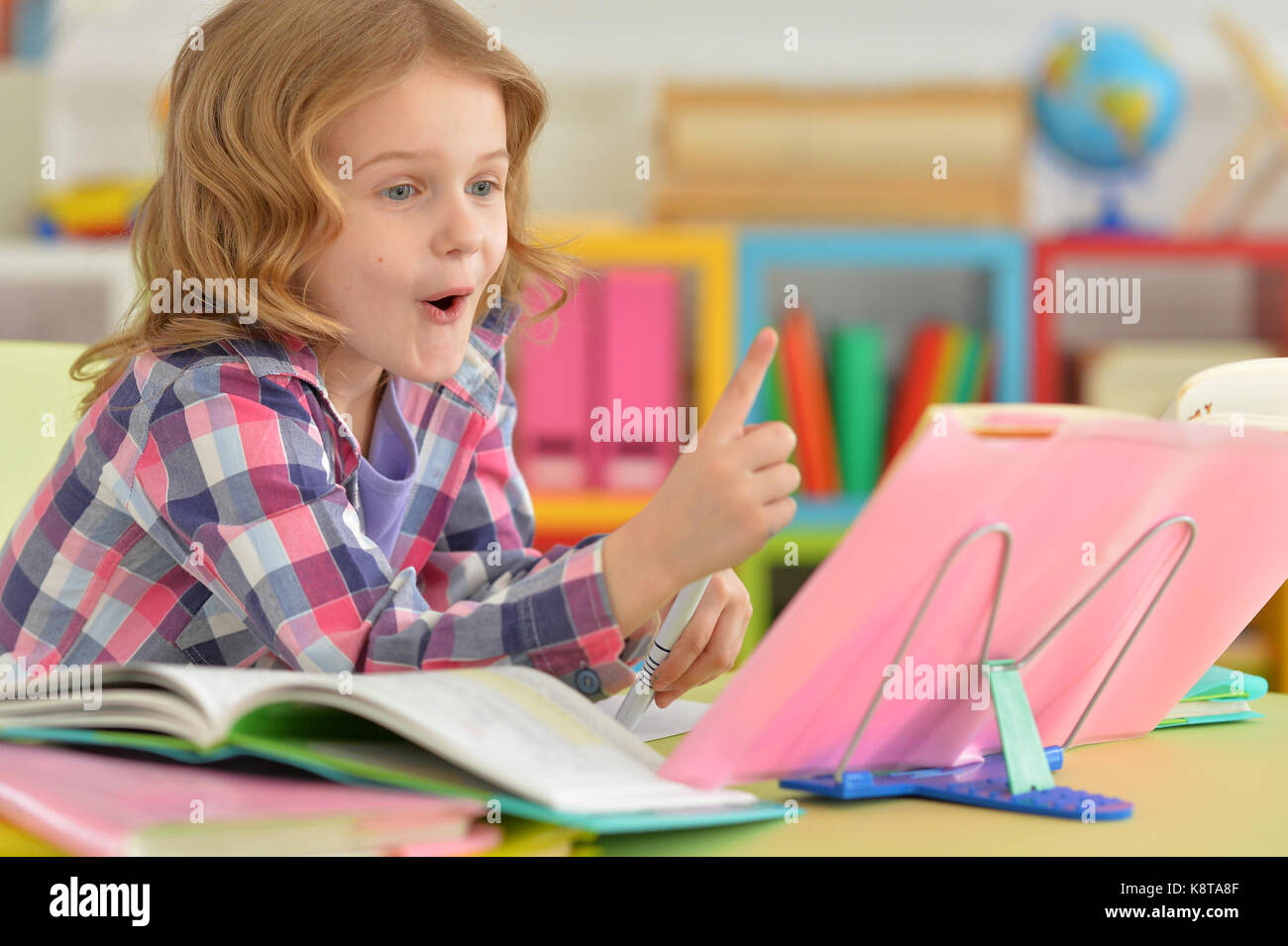 little cute girl doing homewok at the table at home Stock Photo - Alamy