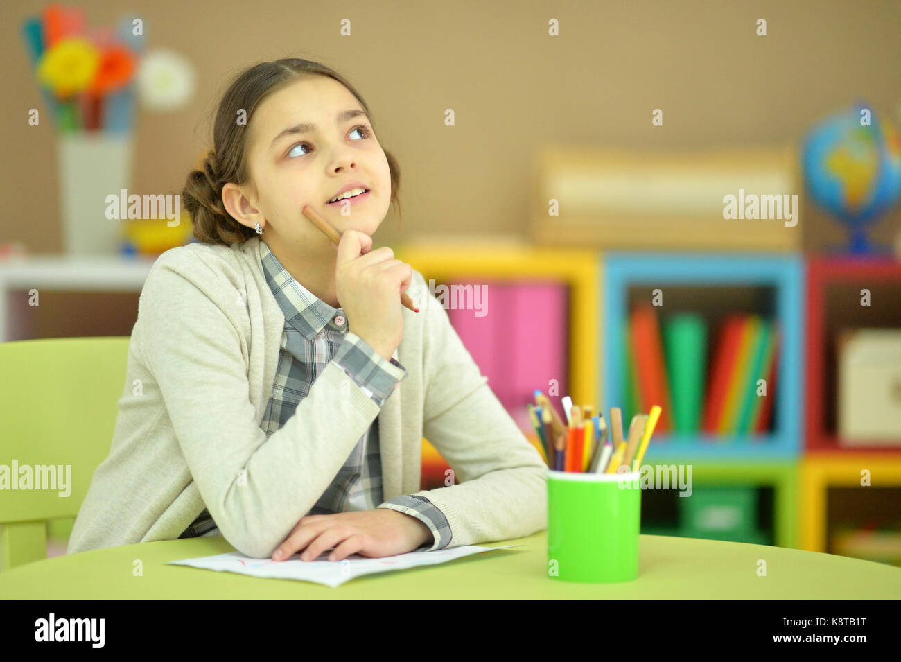 Thoughtful teen girl sitting at table in her room Stock Photo - Alamy