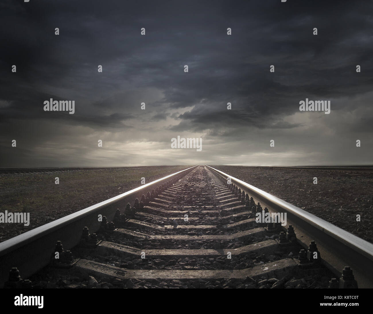 rails going away into the gloomy landscape. Dark image with rails going ...