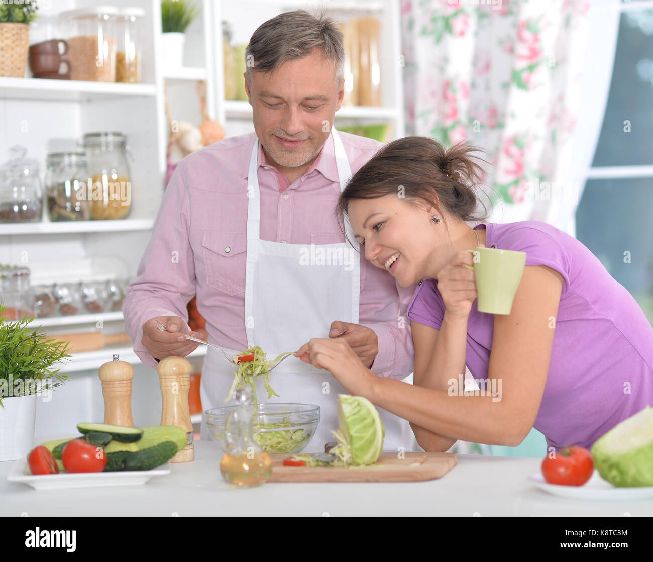Happy married couple cooking together on kitchen Stock Photo - Alamy