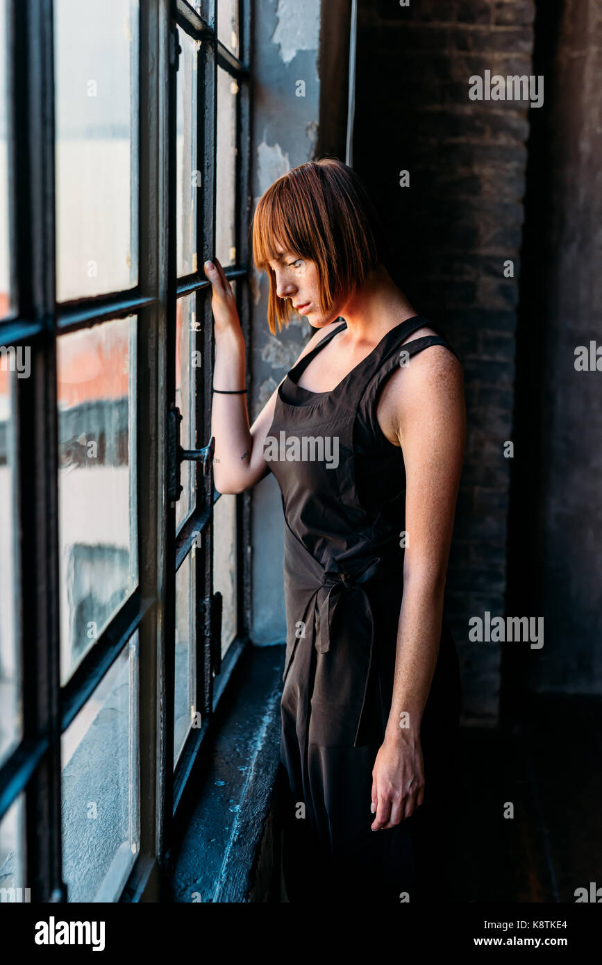 portrait of young beautiful woman indoor looking downward posing ...