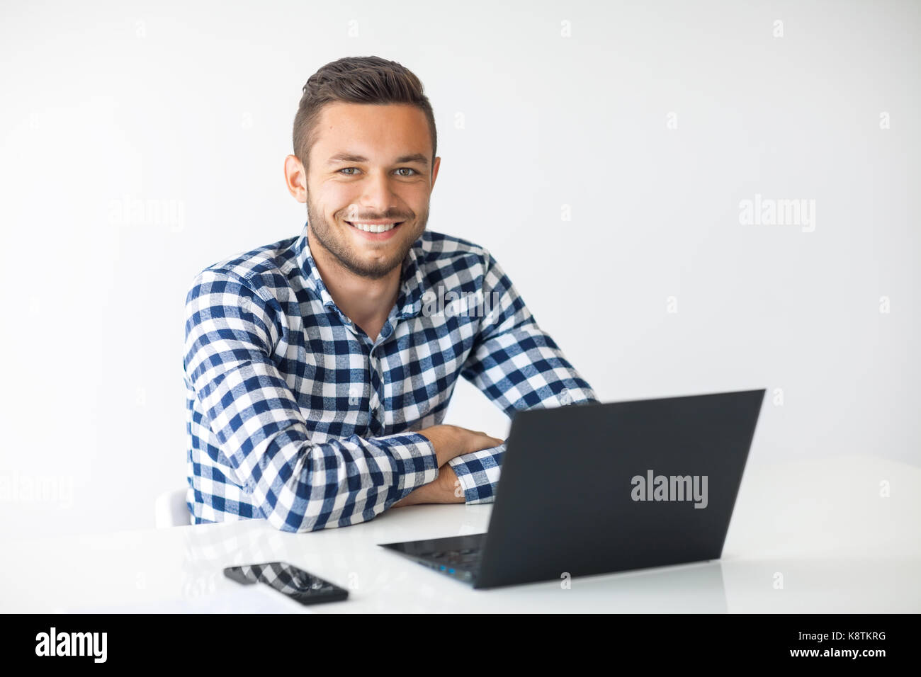 Portrait of handsome smiling man with laptop on white background Stock ...