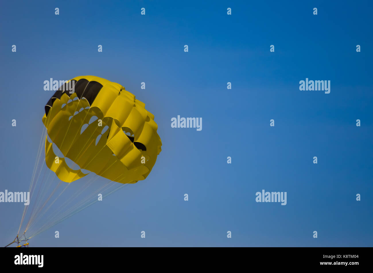 Black and yellow parachute on a blue sky background Stock Photo - Alamy