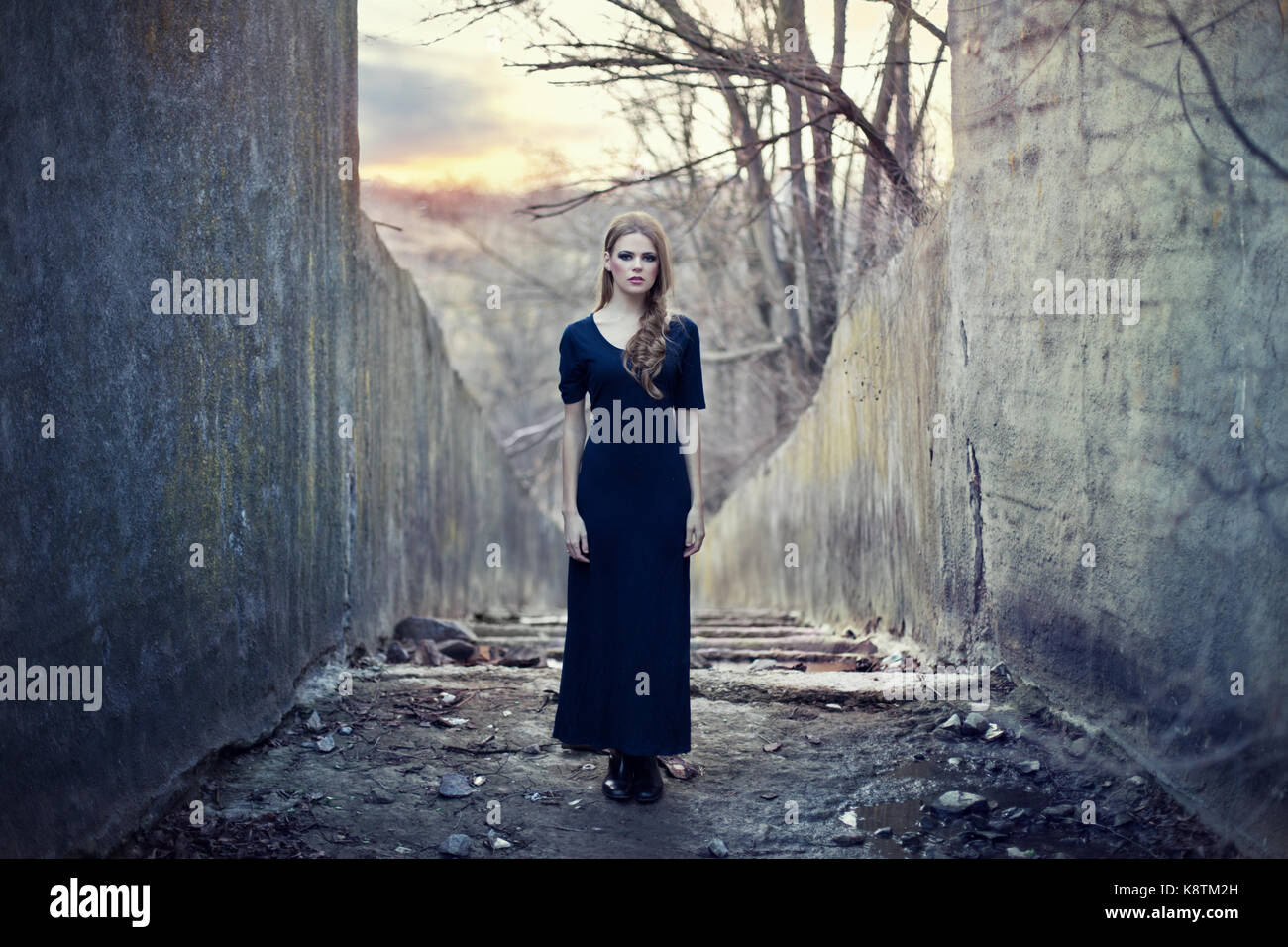 beautiful lonely girl in long dress near gloomy tunnel on sunset Stock ...