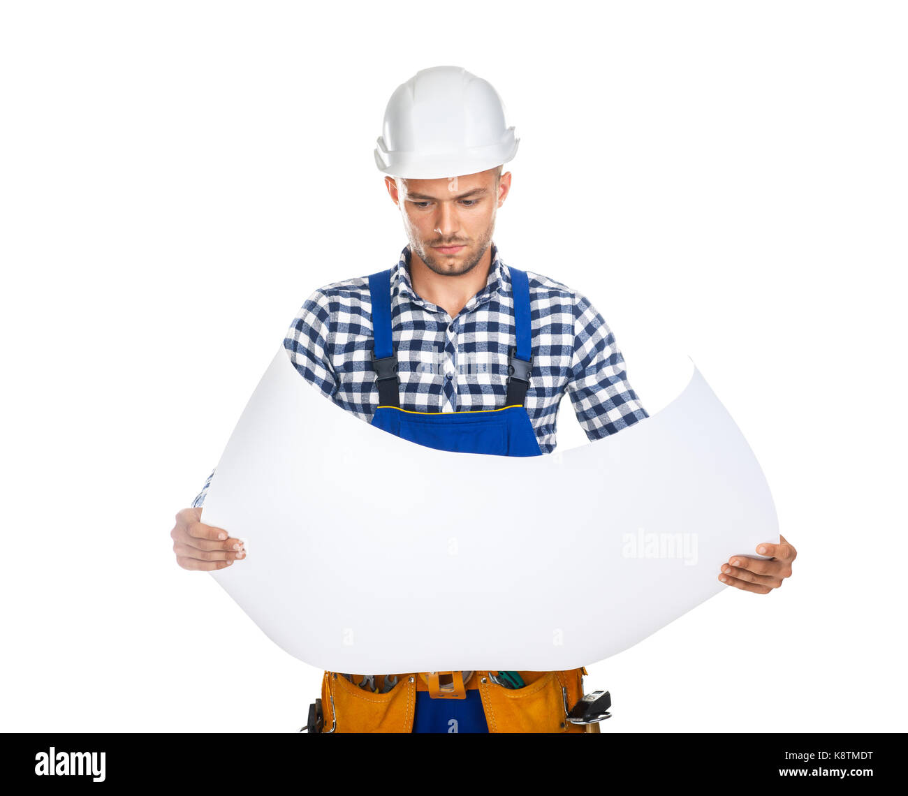 Young handsome engineer looking at blueprint isolated on white ...