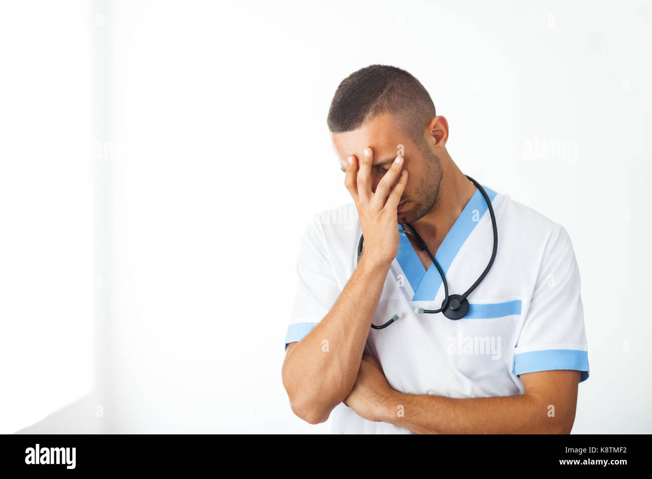 Tired and stressed doctor closed face by hand on white background Stock ...