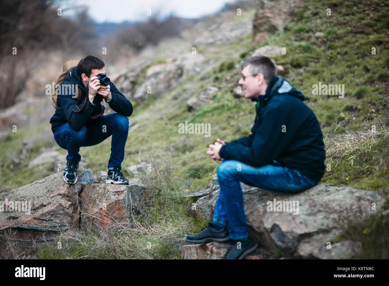 Photographer in action takes pictures of man outdoor Stock Photo - Alamy