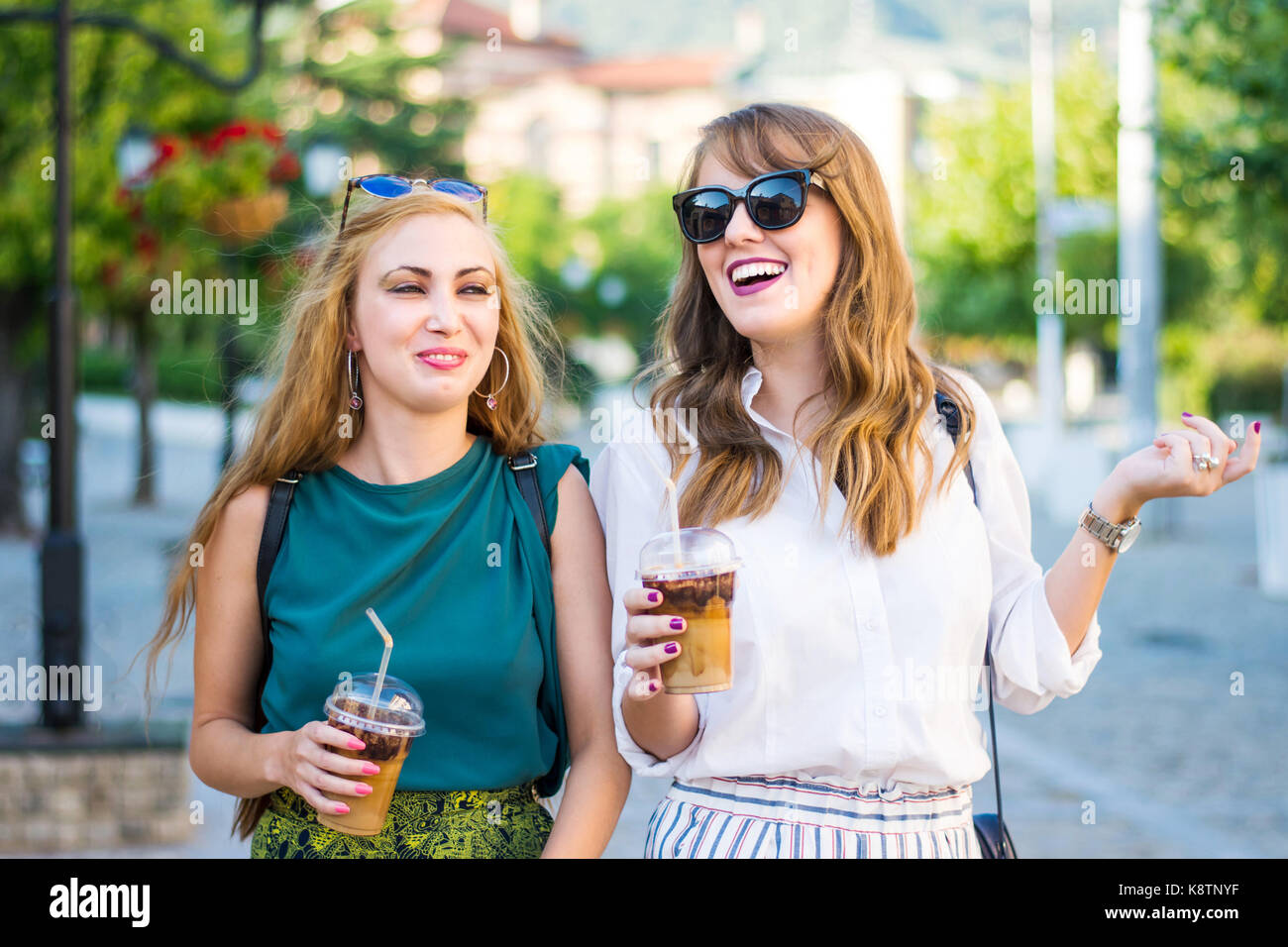 Happy girls walking around the city together Stock Photo - Alamy