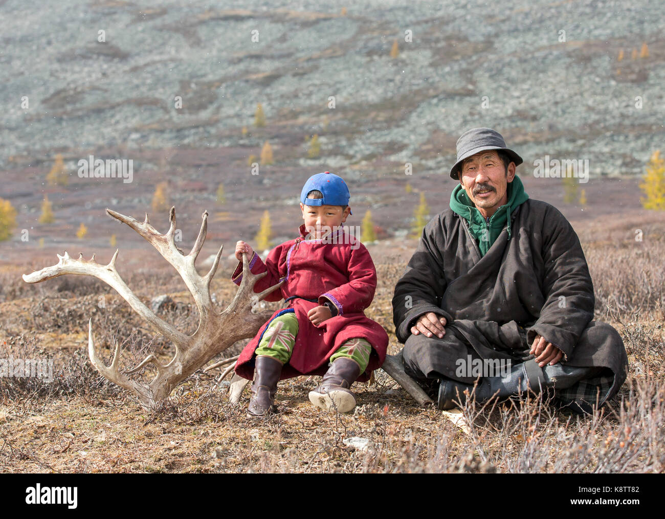 tsaatan nomadic boy and his grandfather in a traditional deels resting ...