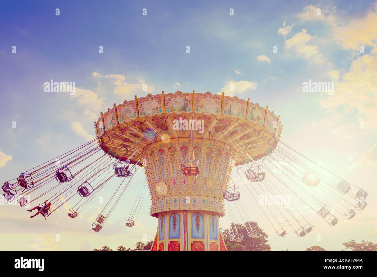 Wave Swinger ride against blue sky, vintage filter effects - a swinging ...