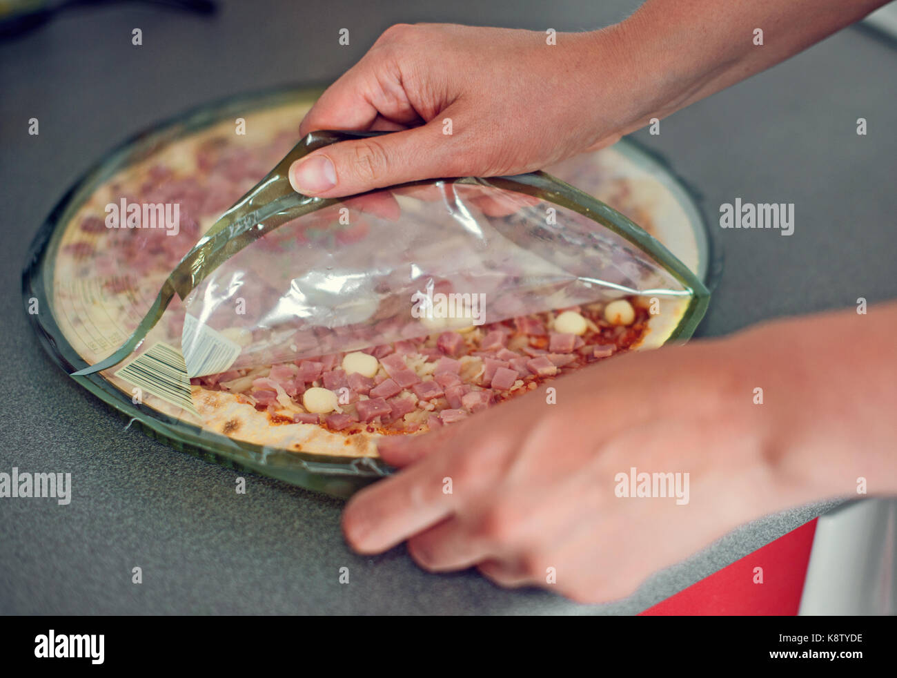 Woman opening pizza bought in a store Stock Photo - Alamy