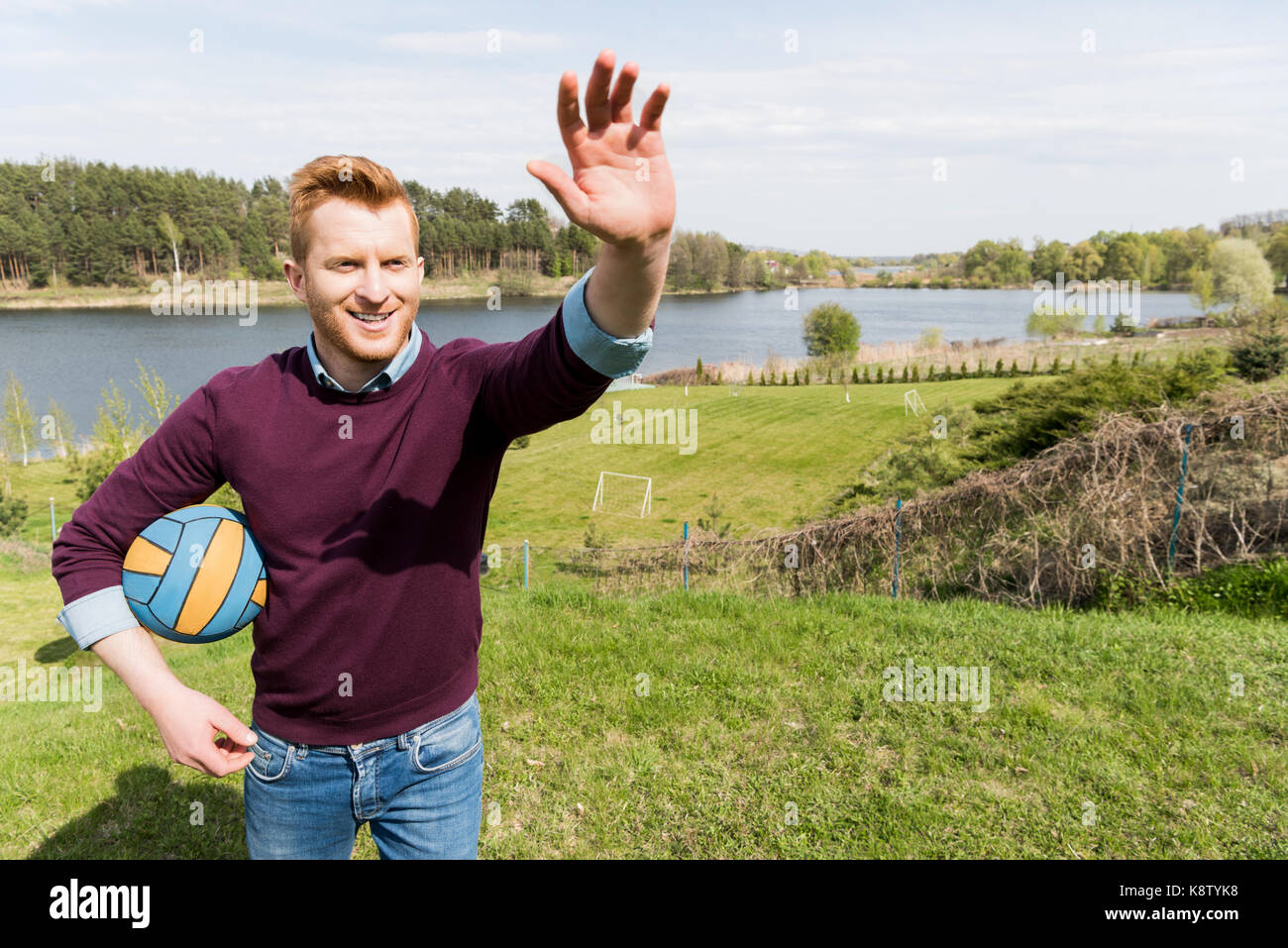 man with ball waving hand Stock Photo - Alamy