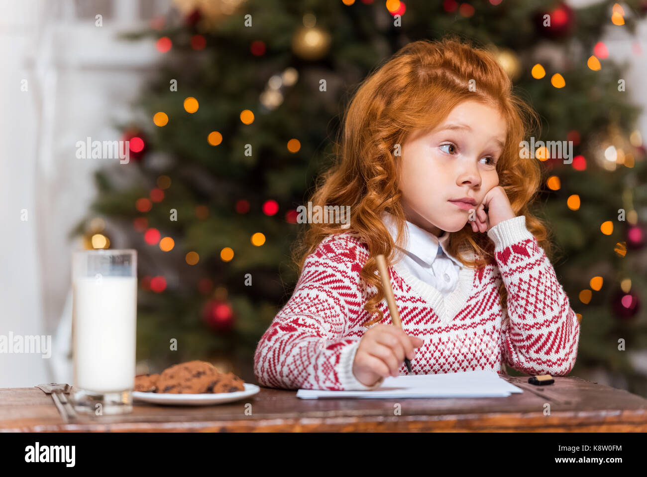 pensive child sitting at table Stock Photo - Alamy