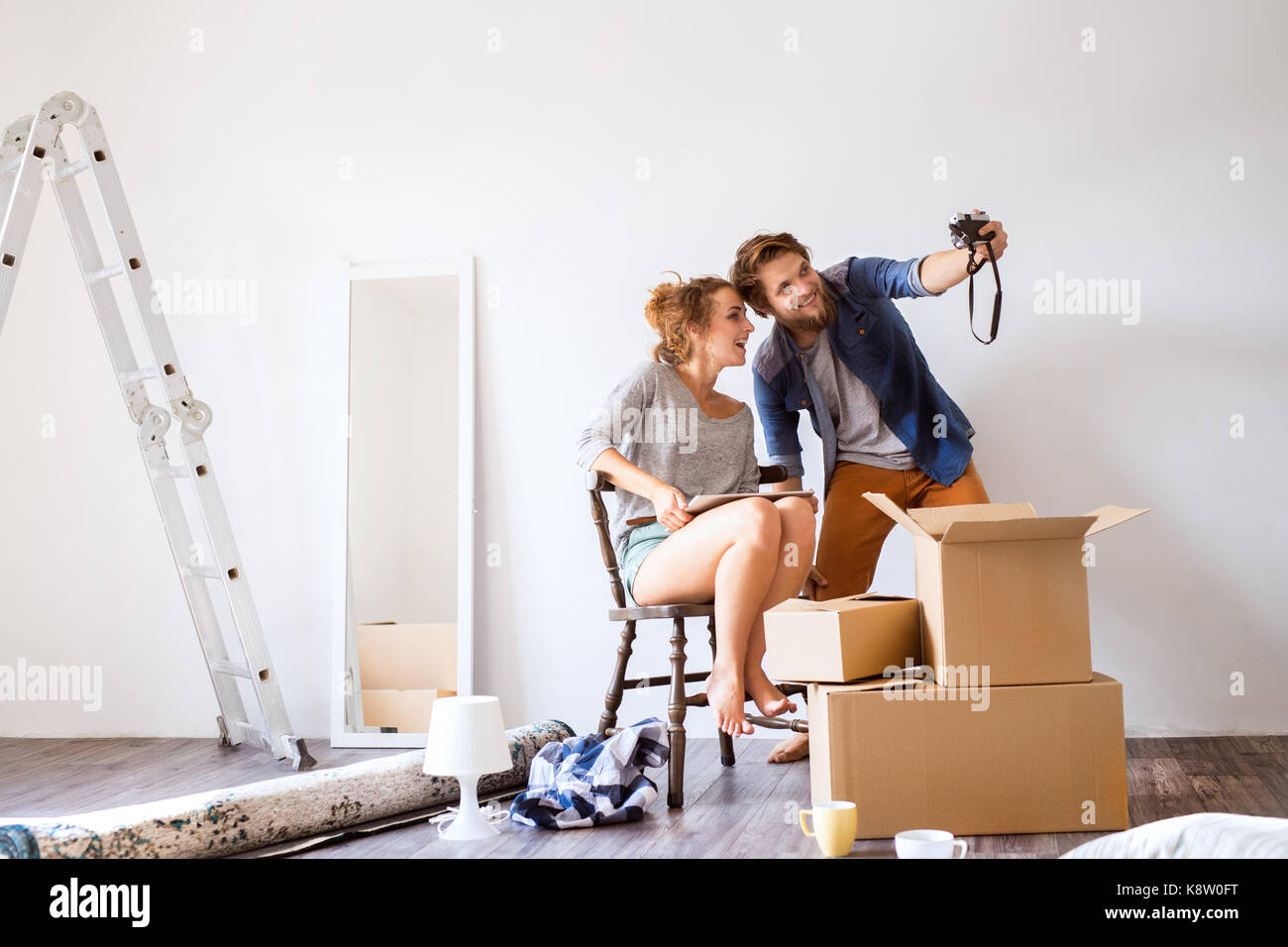 Young couple moving in new house, taking photos Stock Photo - Alamy