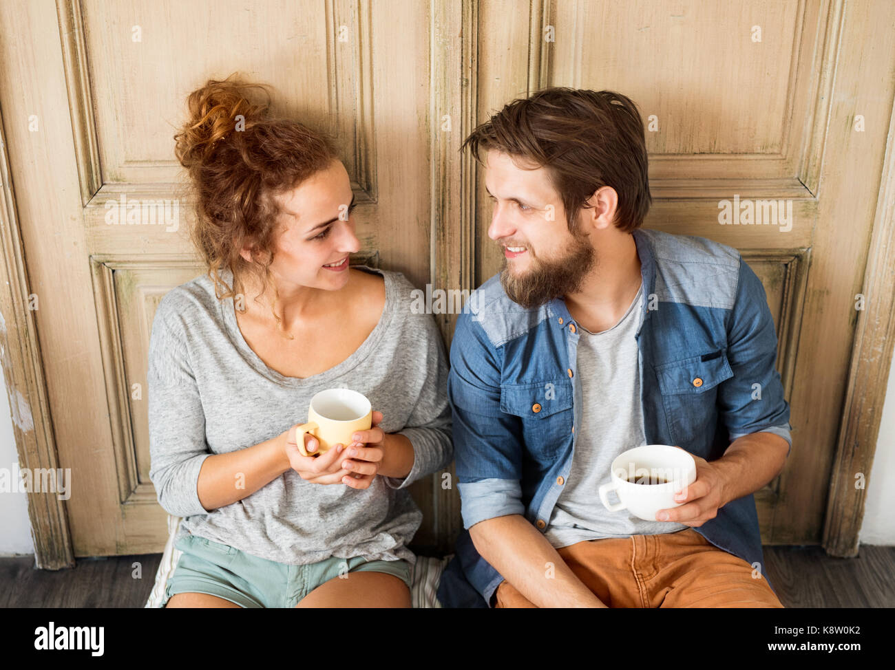 Young couple moving in new house, resting Stock Photo - Alamy