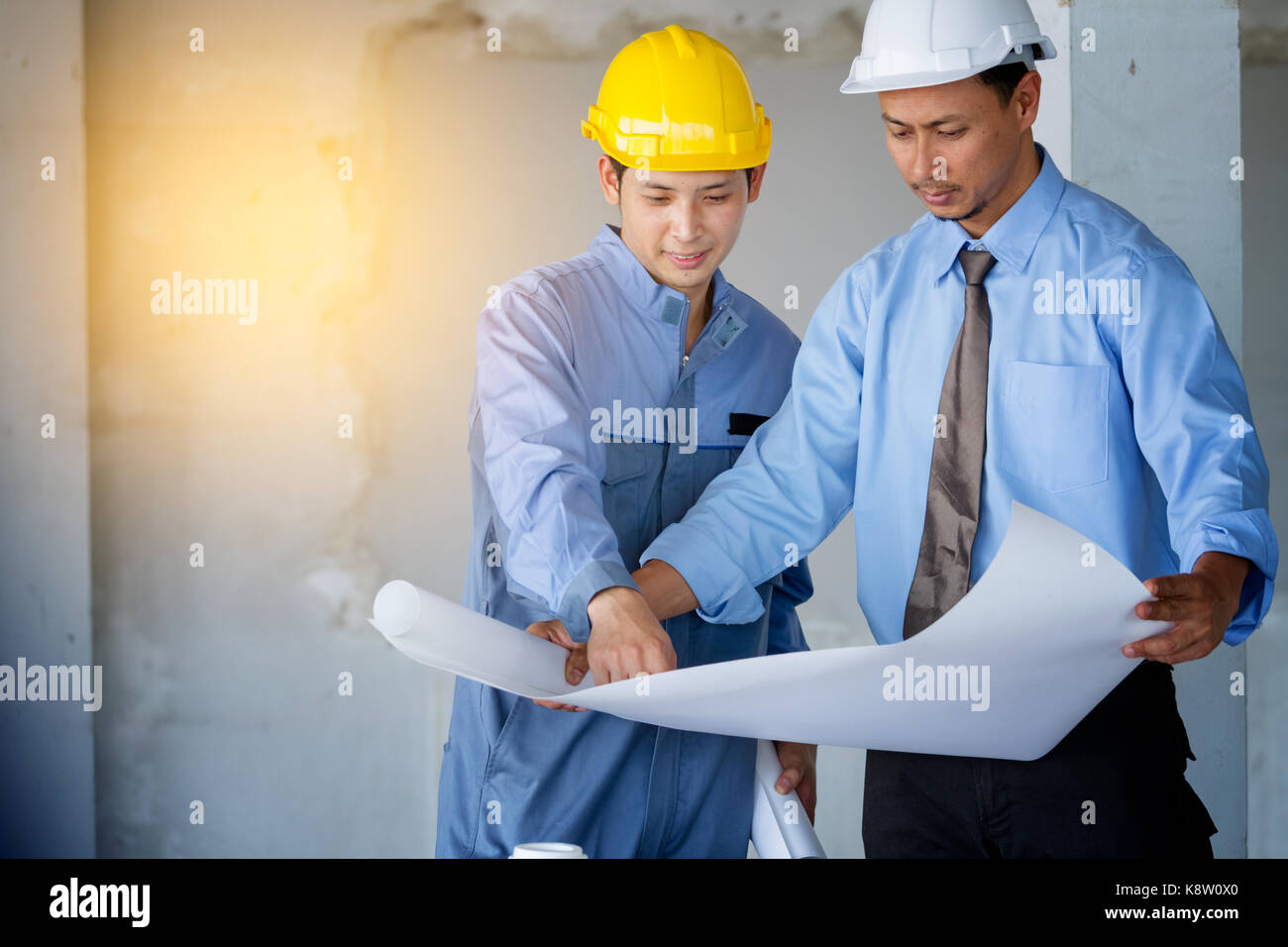 Engineer and worker checking plan on construction site Stock Photo - Alamy