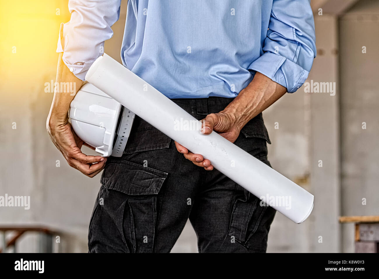 Back view of engineer holding blue print and white helmet Stock Photo ...