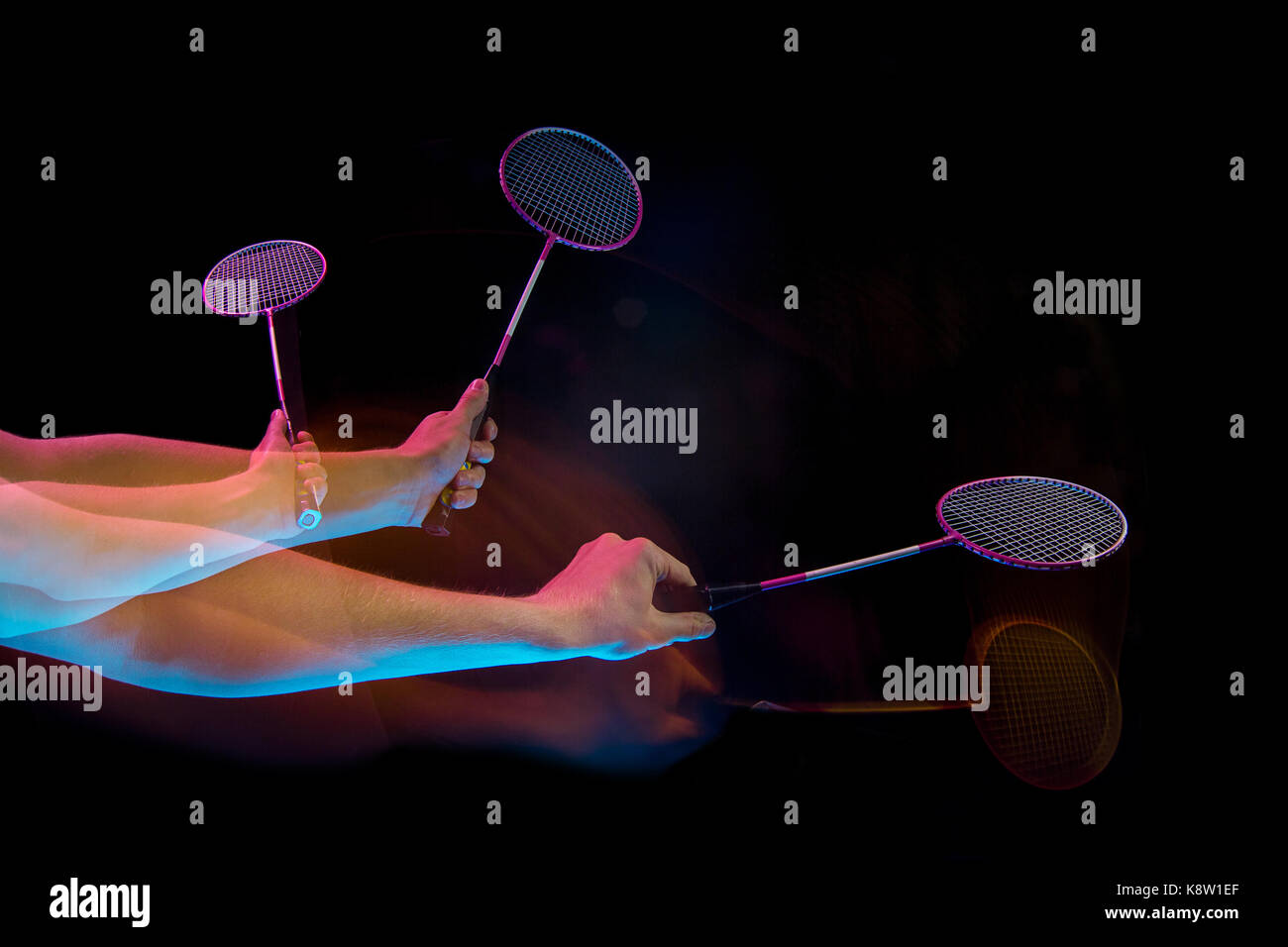 The hands of young man playing badminton over black background Stock ...