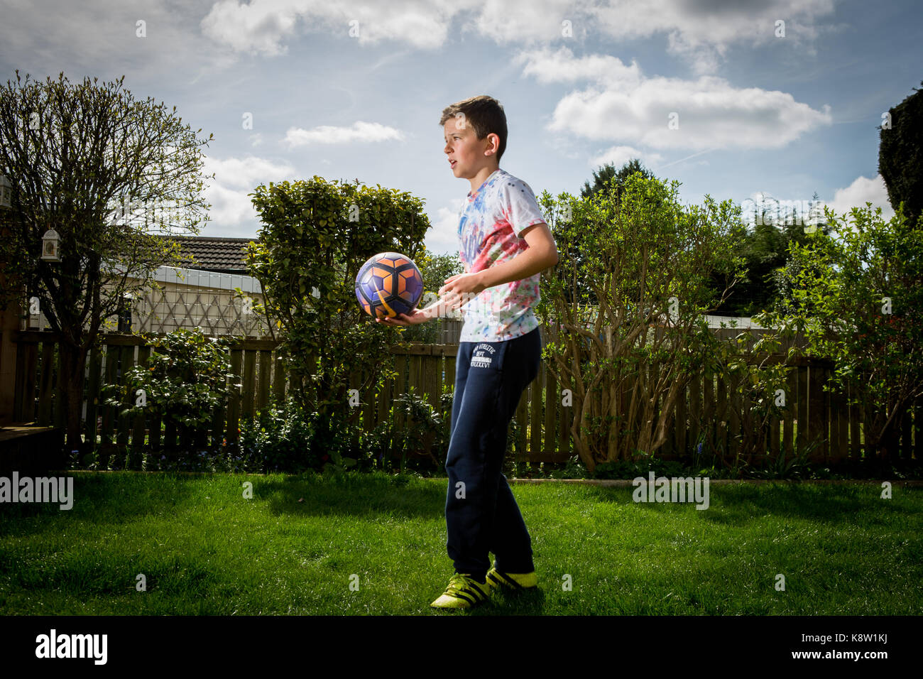 Boy playing football at home Stock Photo - Alamy