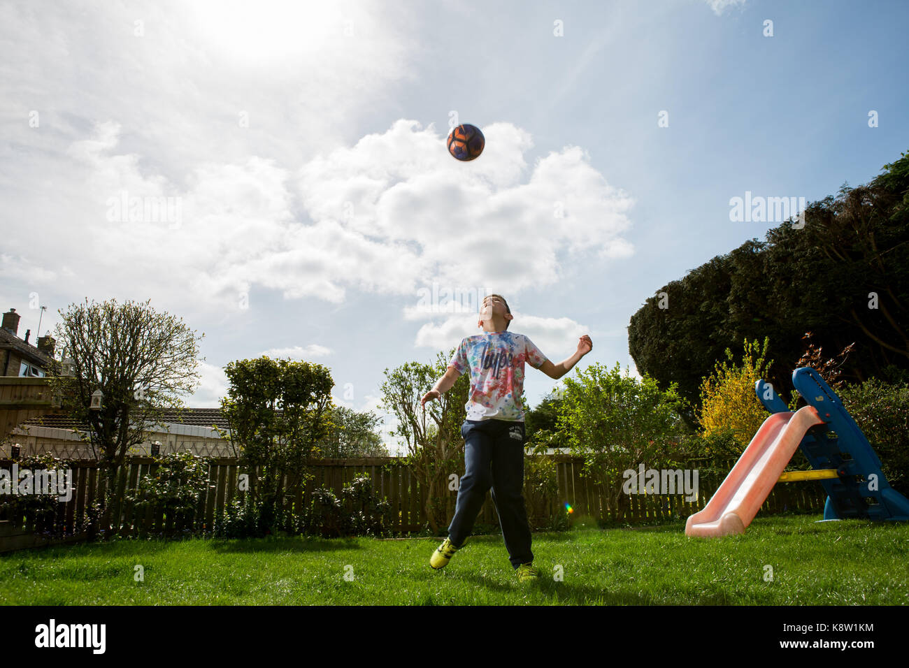 Boy playing football at home Stock Photo - Alamy