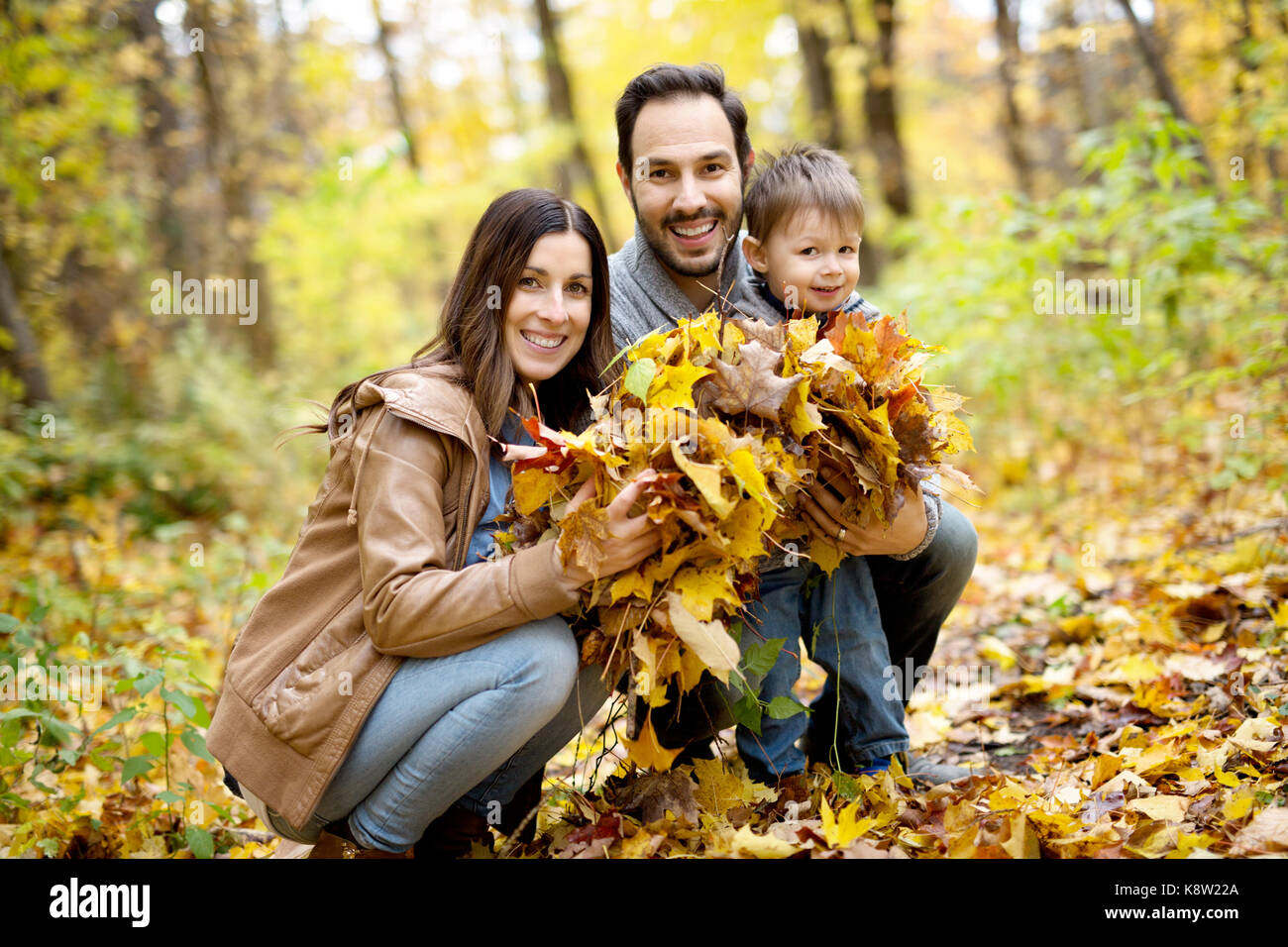 Happy family relaxing outdoors In autumn park Stock Photo - Alamy
