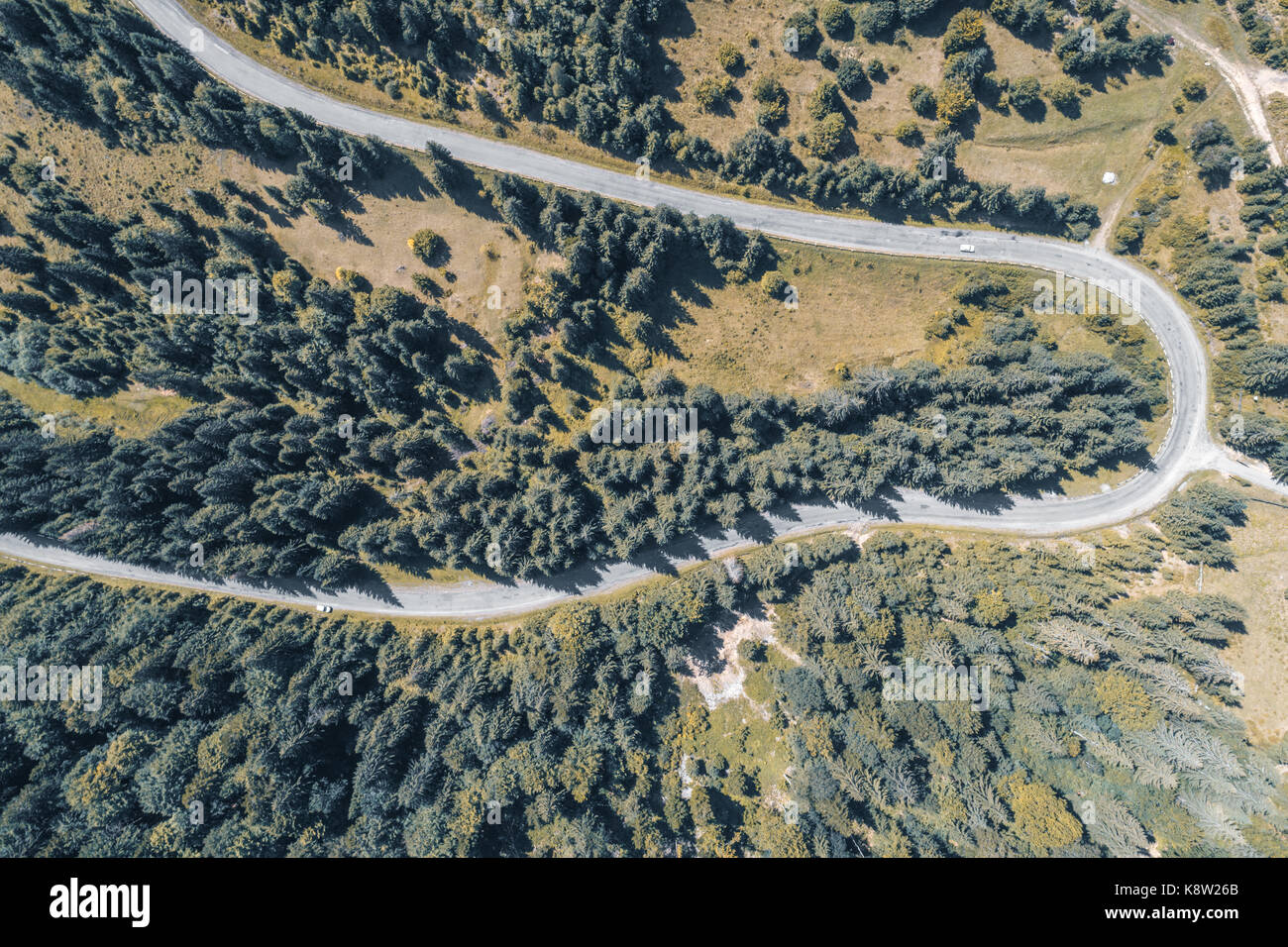 Aerial view over mountain road going through forest landscape Stock ...
