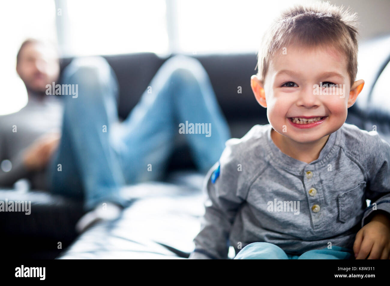 Father And Children On Sofa At Home Watching TV Together Stock Photo ...