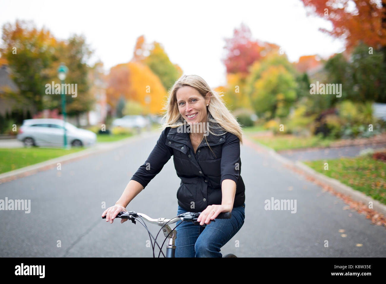 Woman on bicycle smiling Stock Photo - Alamy
