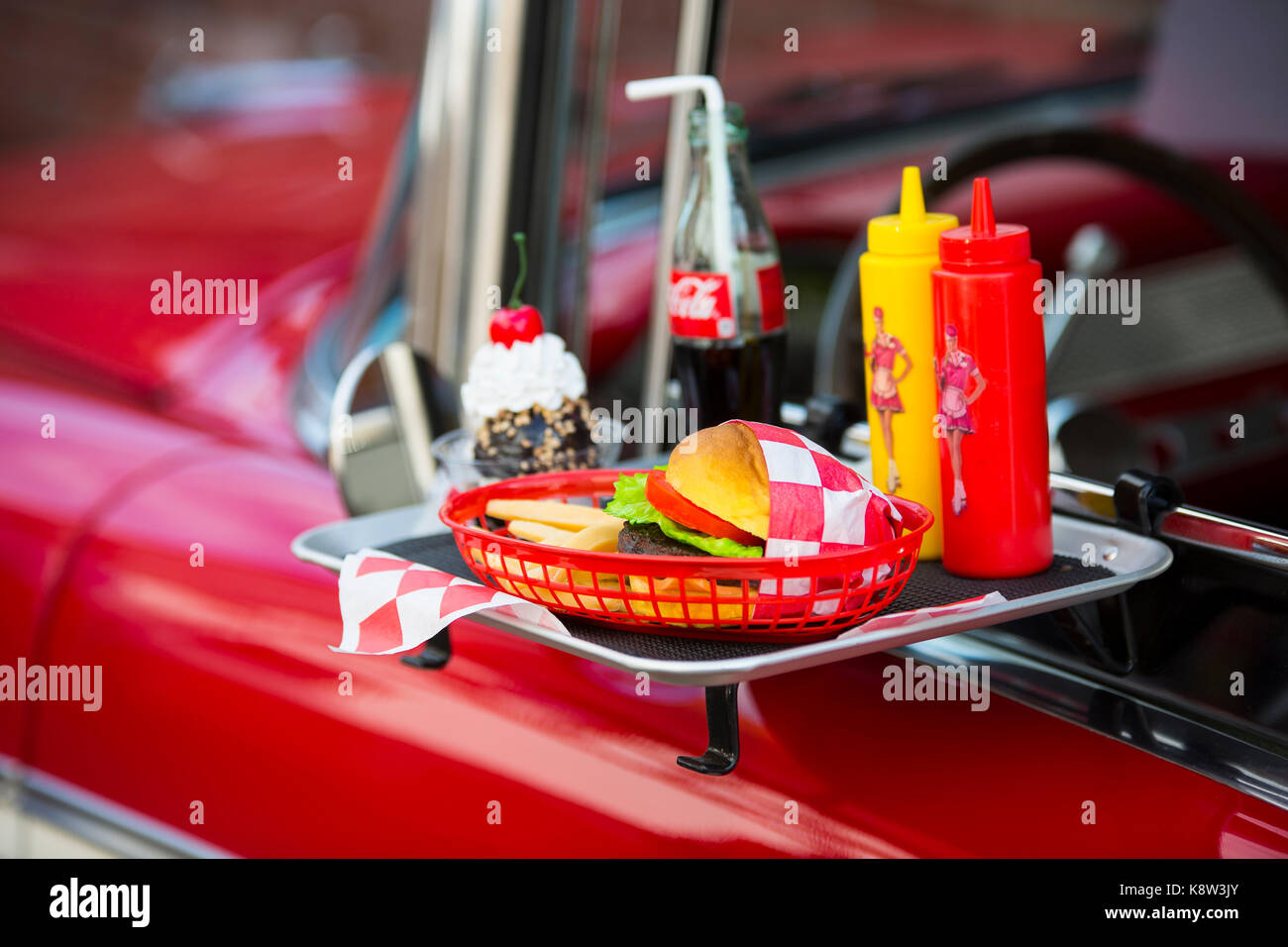 Fast food menu on a tray on door of Cadillilac classic car. Credit ...