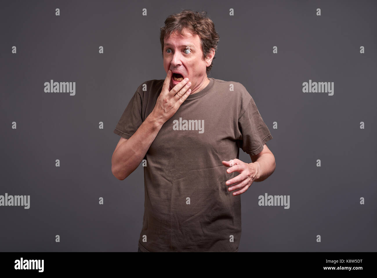 A middle aged man standing and feeling scared Stock Photo - Alamy