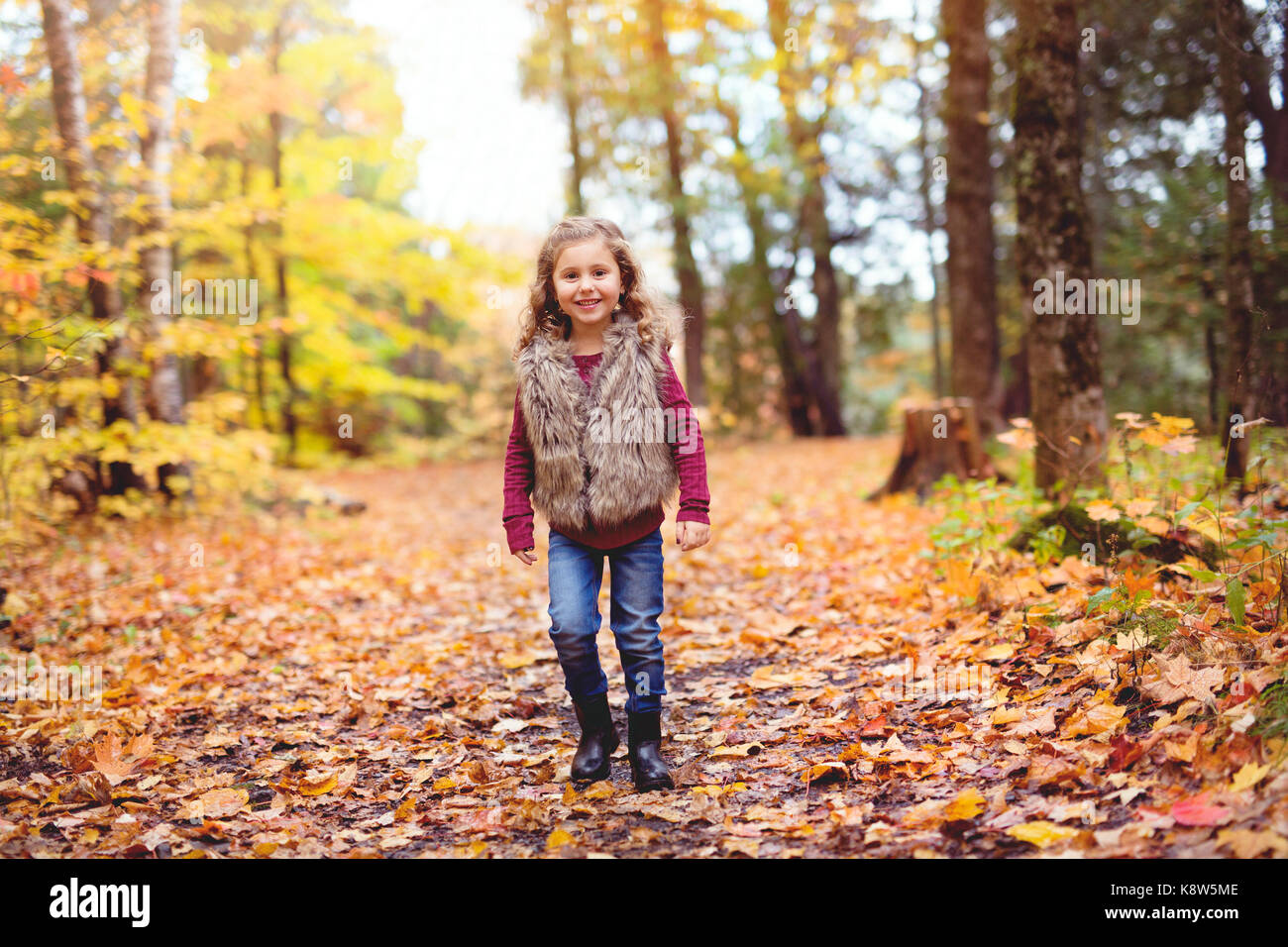 Adorable little girl in a autumn forest Stock Photo - Alamy