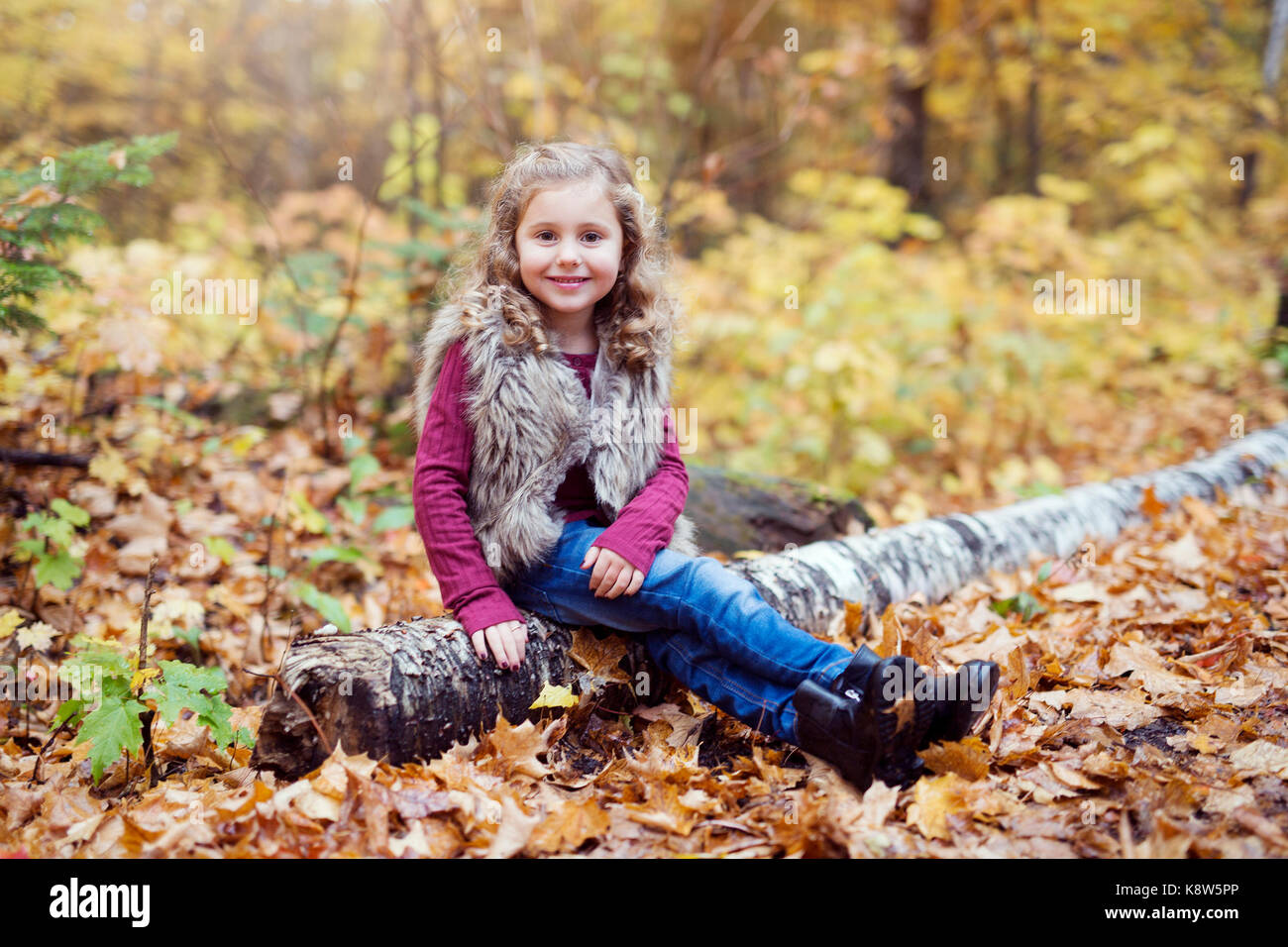 Adorable little girl in a autumn forest Stock Photo - Alamy