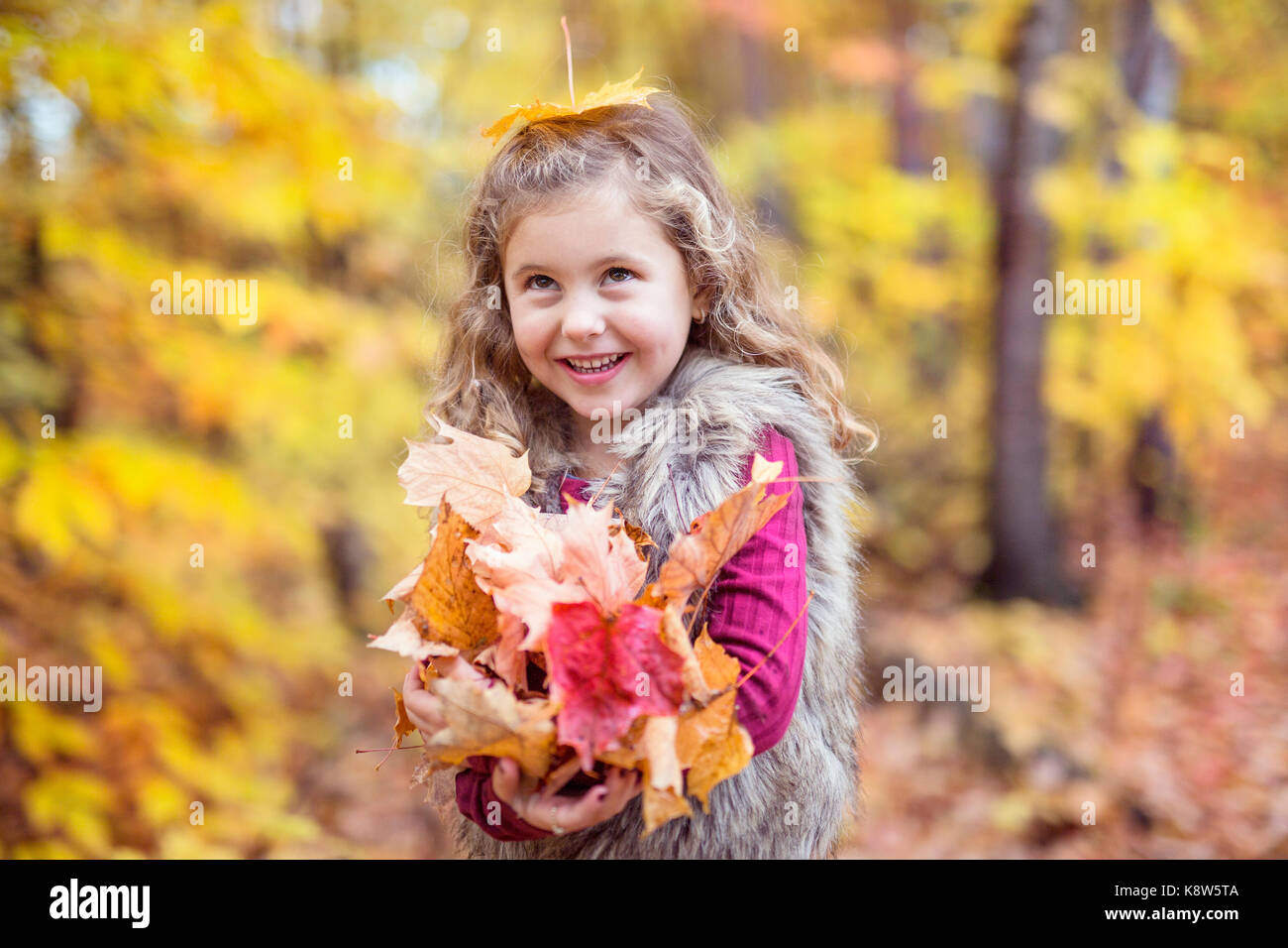 Adorable little girl in a autumn forest Stock Photo - Alamy