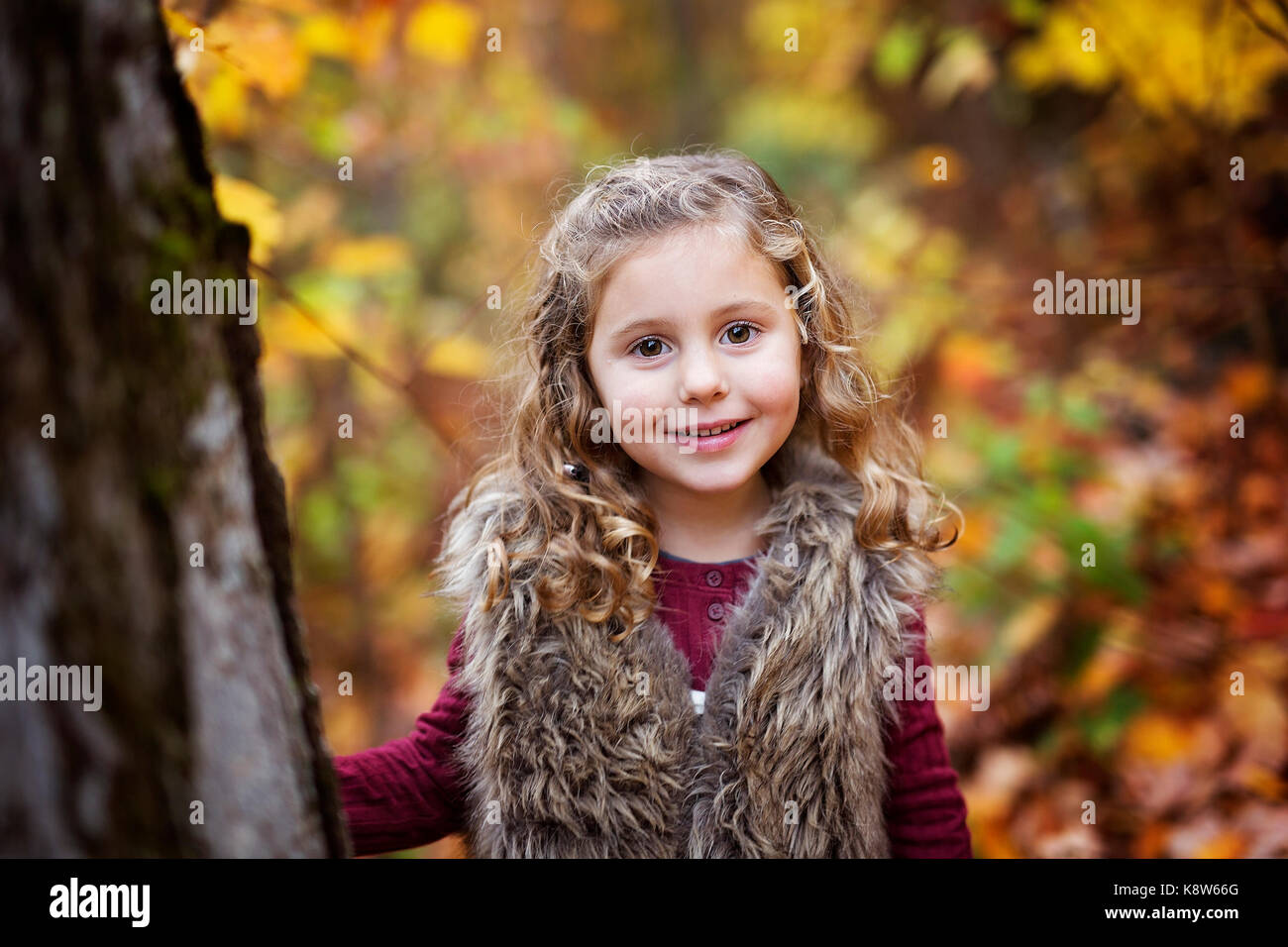 Adorable little girl in a autumn forest Stock Photo - Alamy