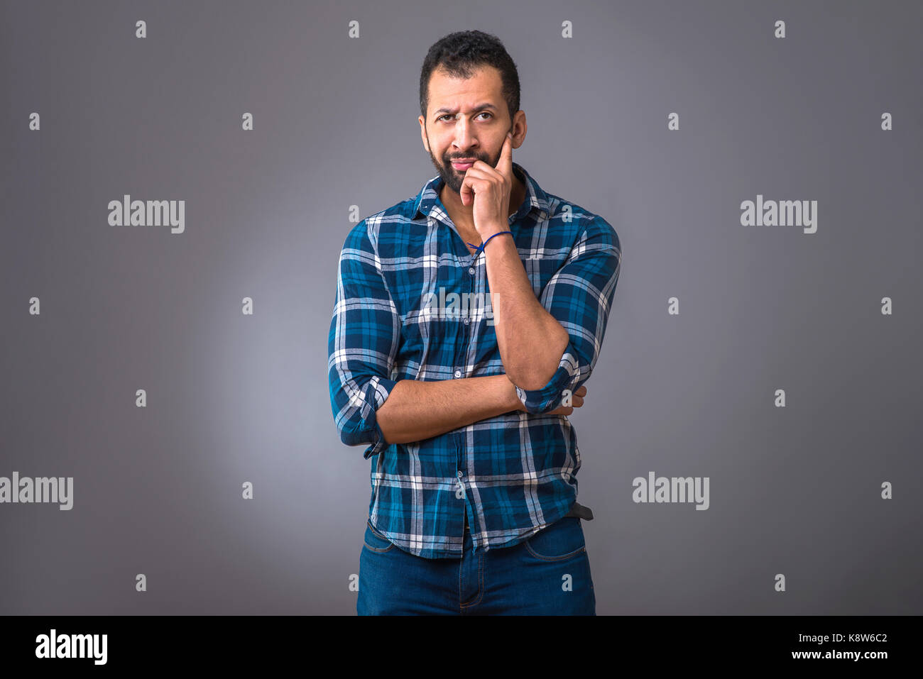 A young black man standing and thinking Stock Photo - Alamy
