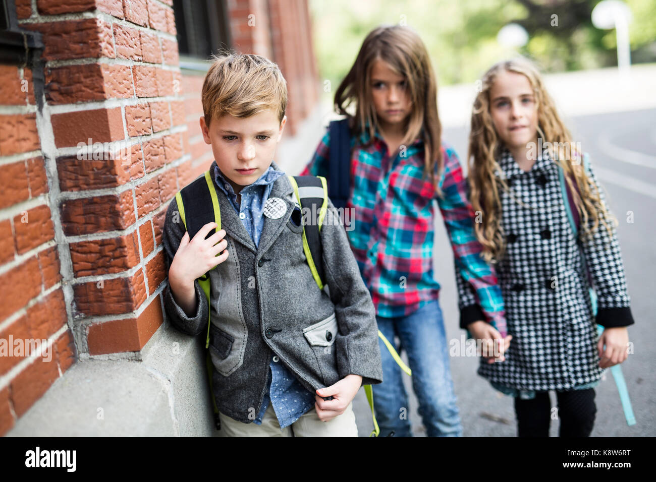 Pupils friends teasing a pupil alone primary school Stock Photo - Alamy